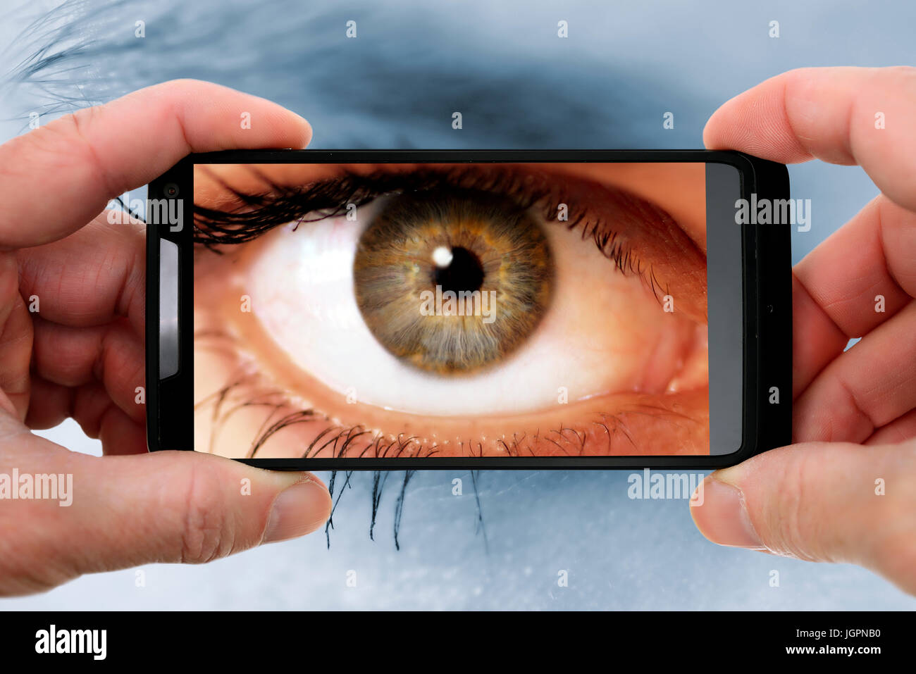 A woman's eye in a camera mobile phone, gawker Stock Photo - Alamy