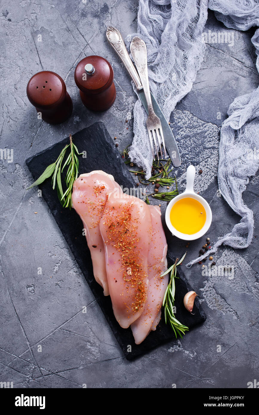 raw chicken fillet with spice on a table Stock Photo - Alamy