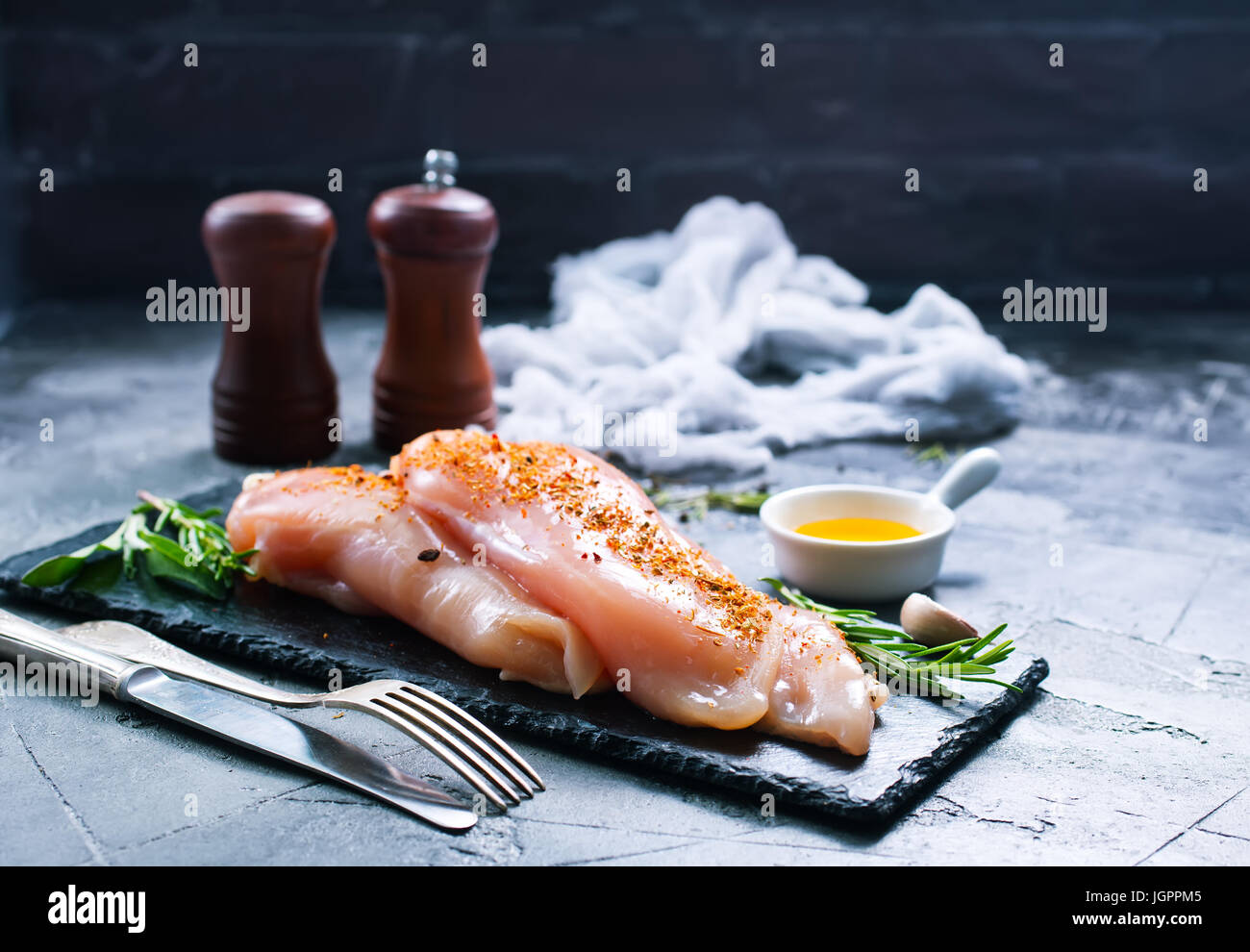 raw chicken fillet with spice on a table Stock Photo - Alamy