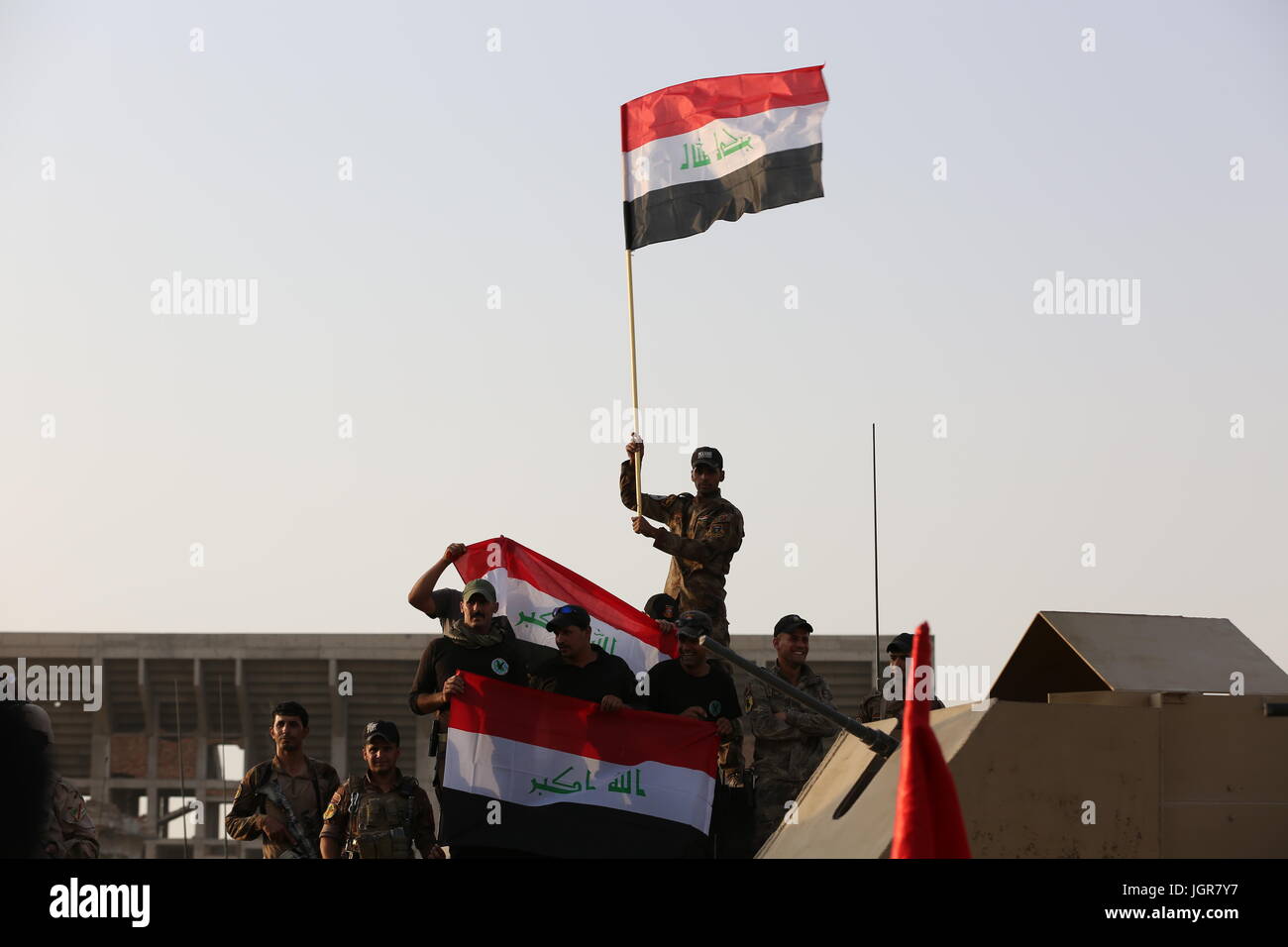 Mosul, Iraq. 10th July, 2017. Iraqi soldiers hold national flags during ...