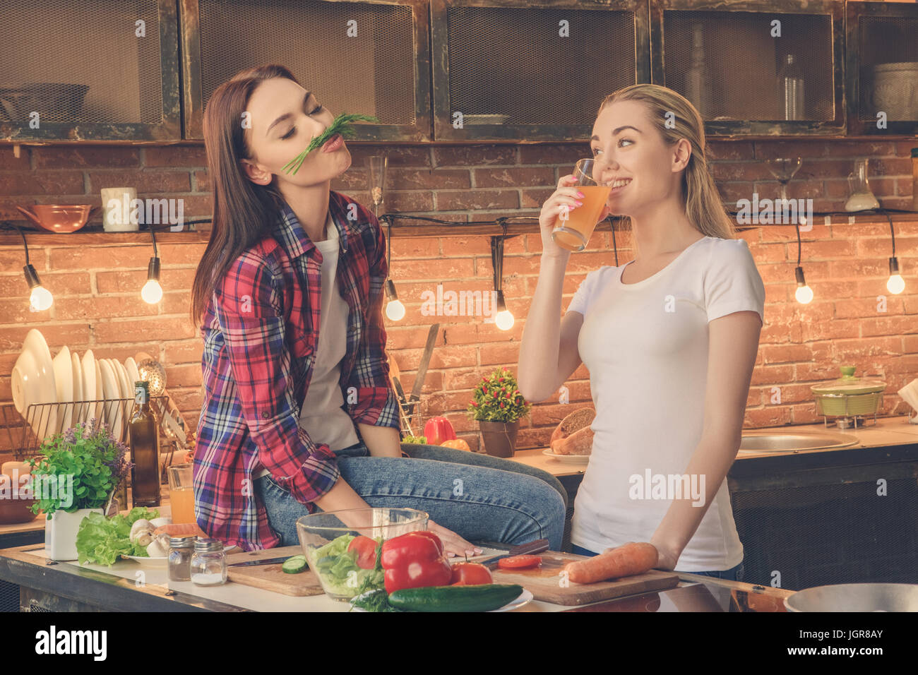 Young women friends cooking meal together at home Stock Photo - Alamy
