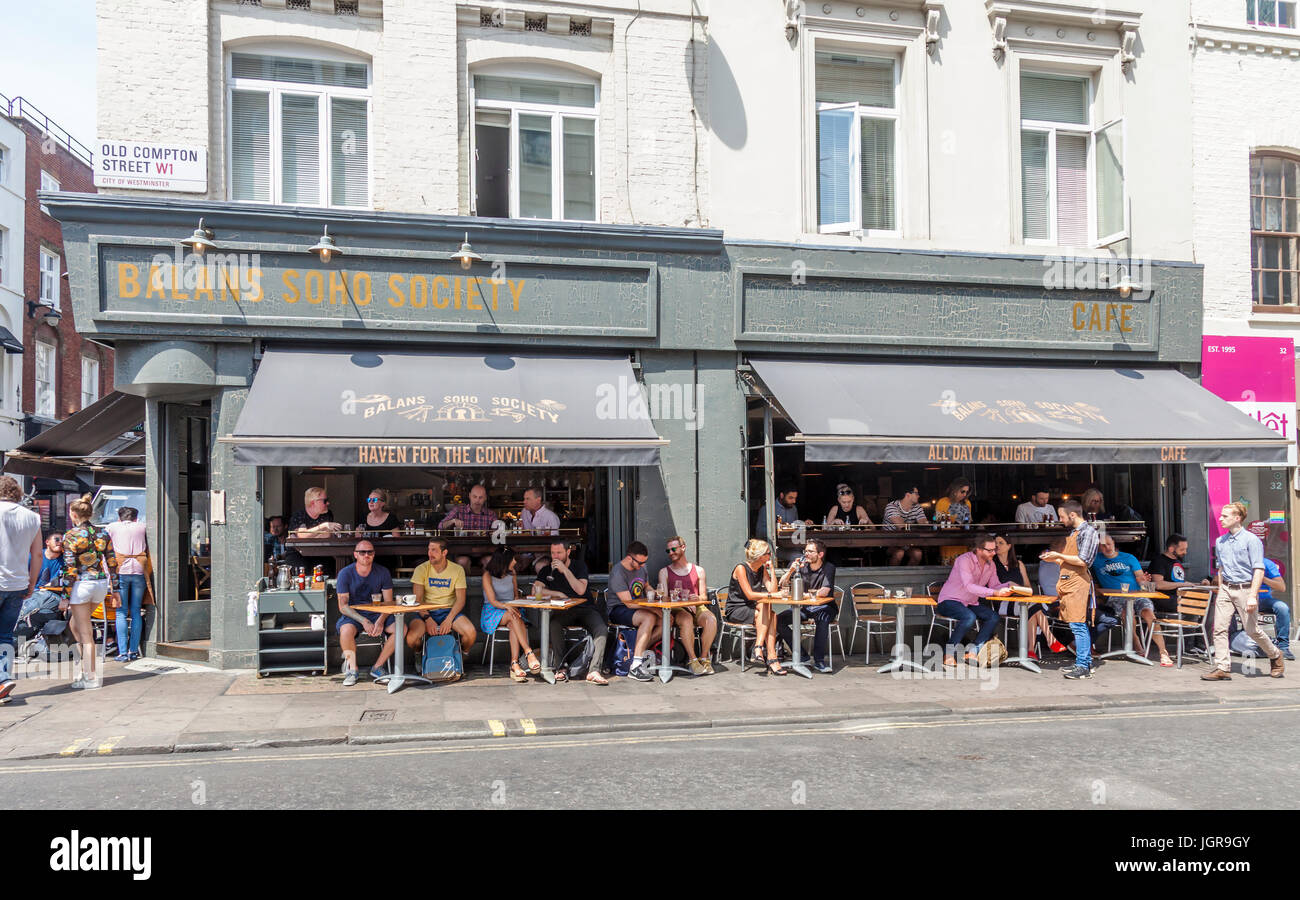 Customers relaxing, eating and drinking inside and outside Balans Soho ...