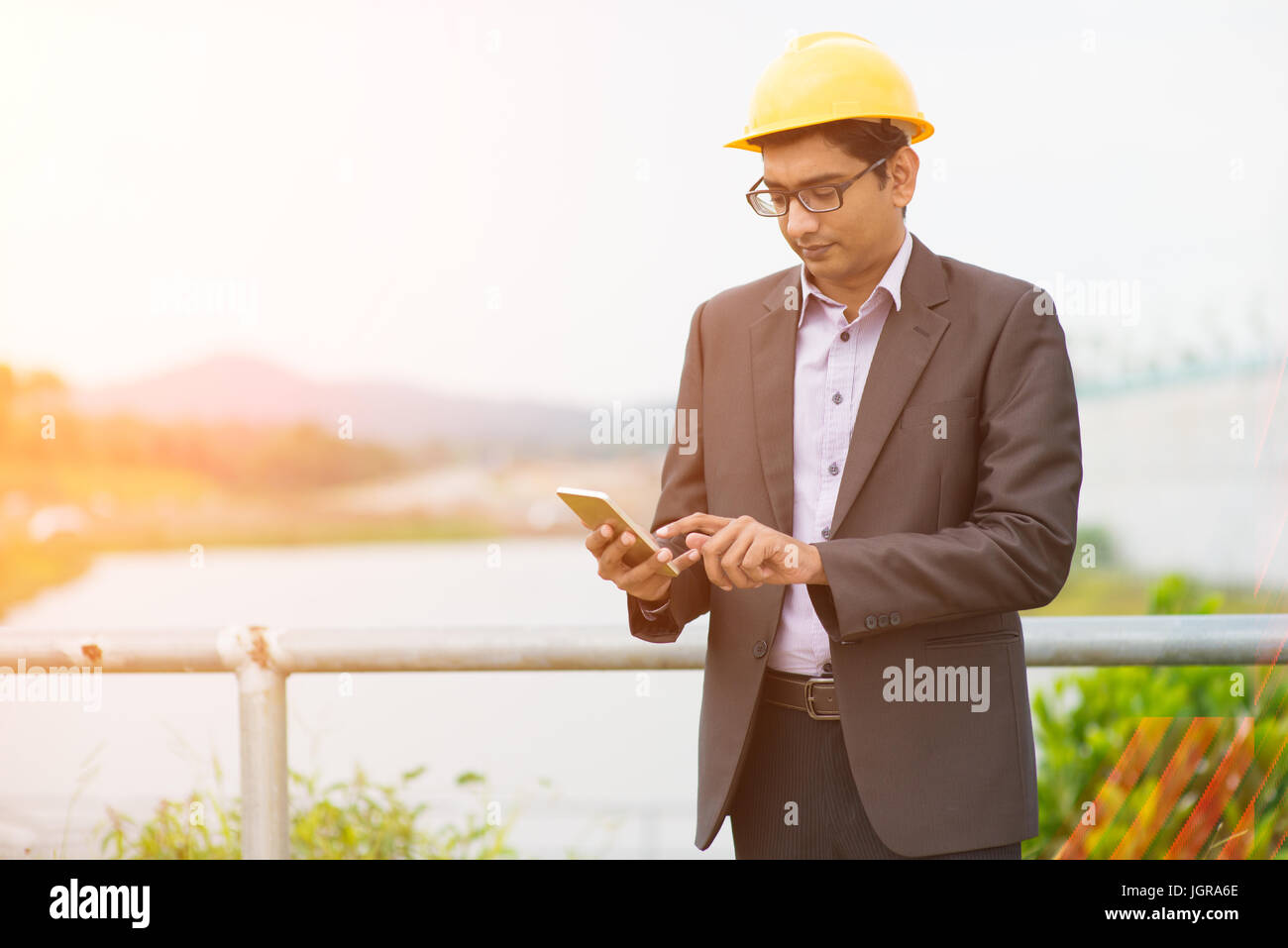 indian male engineer using phone on the lakeside Stock Photo - Alamy