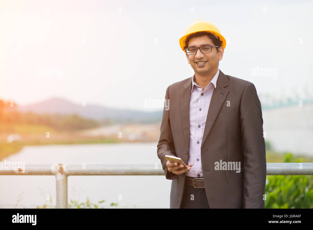 indian male engineer using phone on the lakeside Stock Photo - Alamy