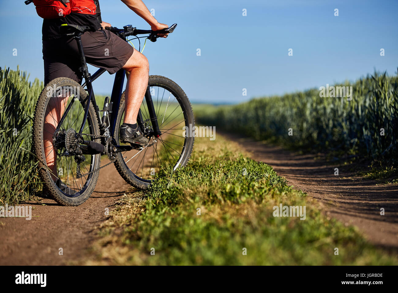 Close-up of cyclist man legs with mountain bike on the path of the ...