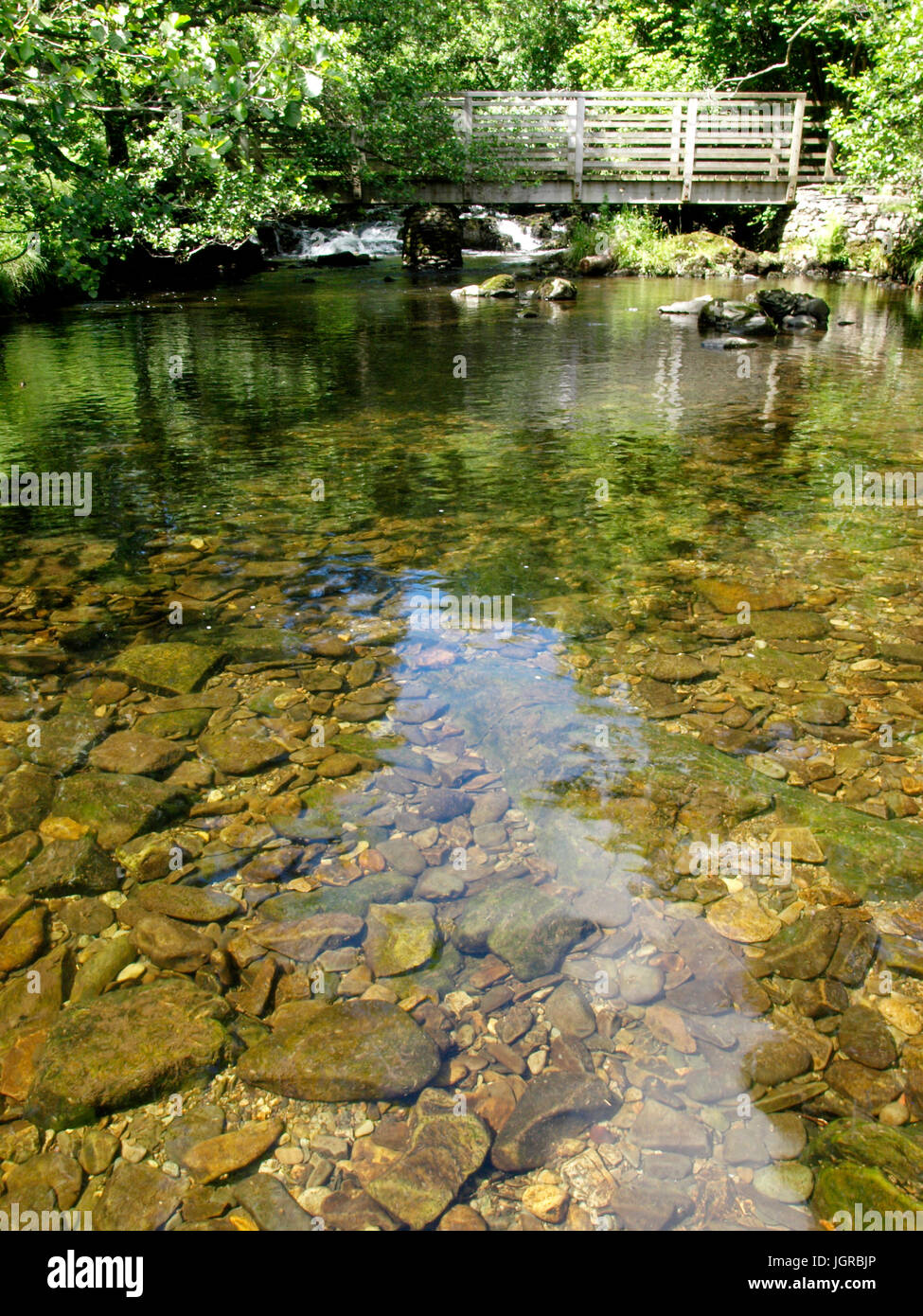 Small river running under a bridge with water so clear you can see the ...