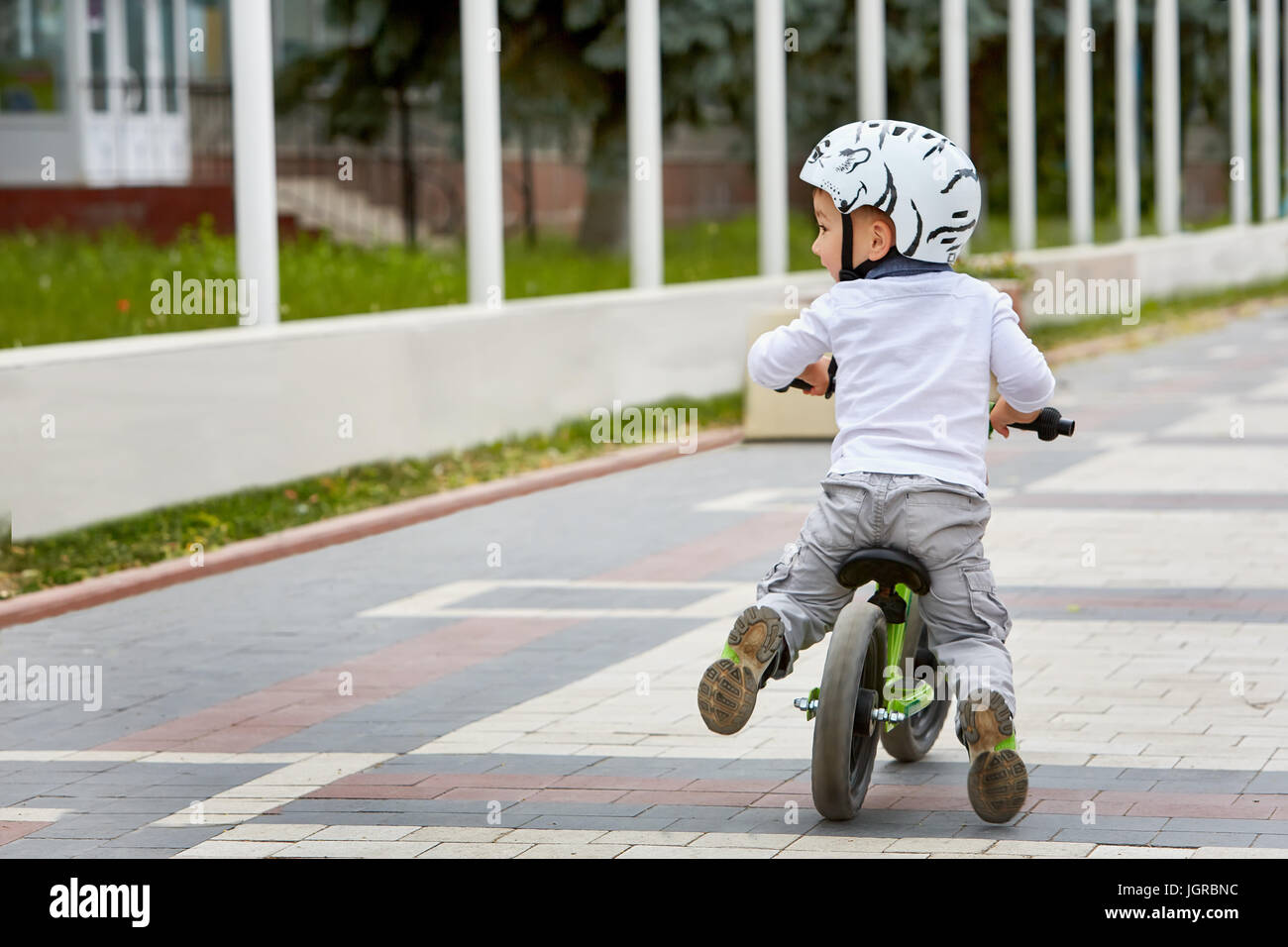 Child boy in white helmet riding on his first bike with a helmet. Bike ...