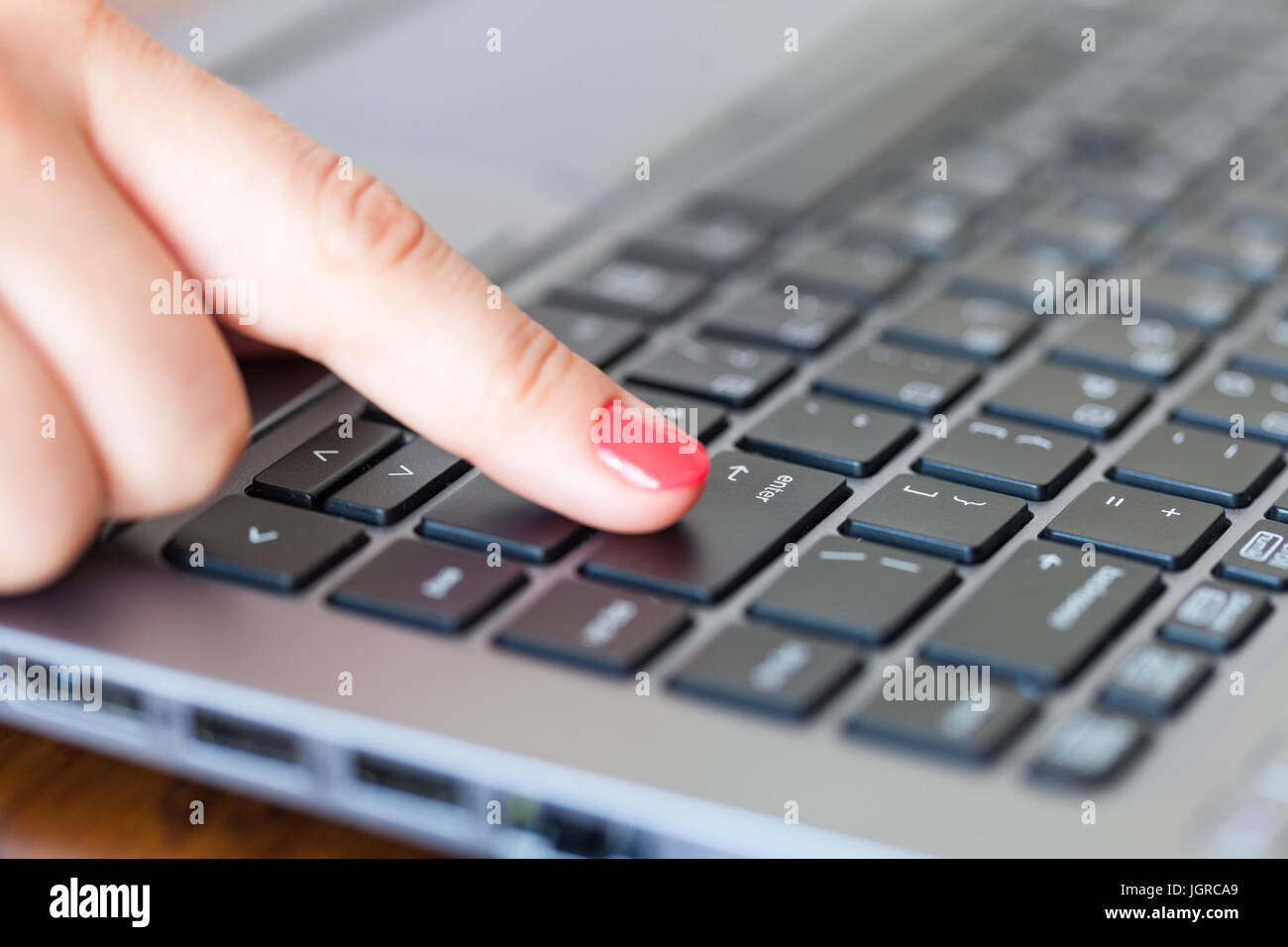 Female hand pressing enter key, shallow field of depth Stock Photo - Alamy