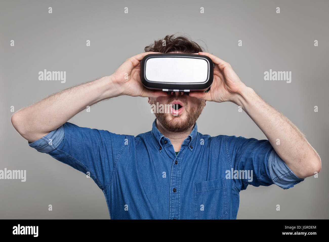 Man wearing virtual reality goggles, shot on grey Stock Photo - Alamy