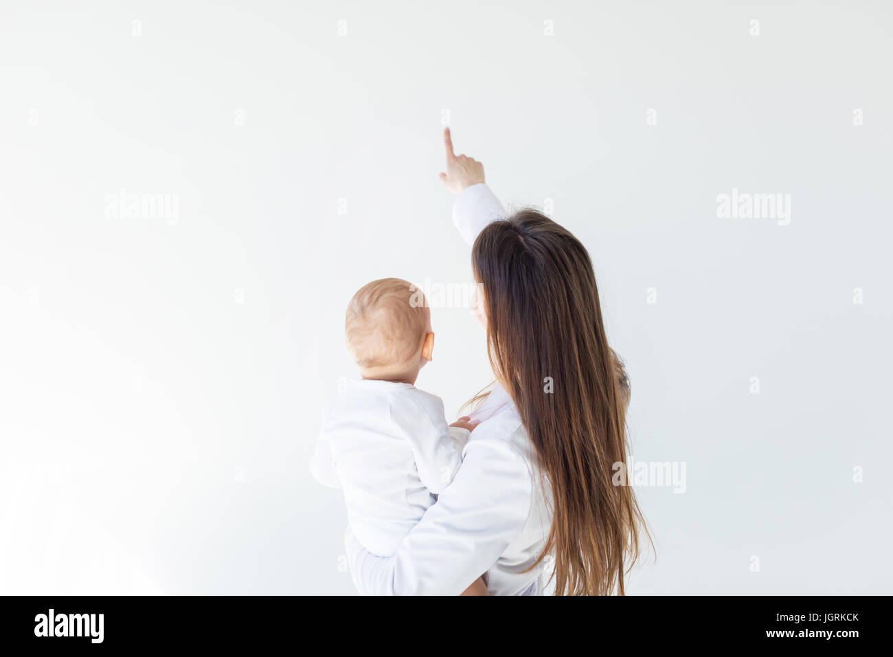 rear view of mother holding adorable baby boy and pointing isolated on ...