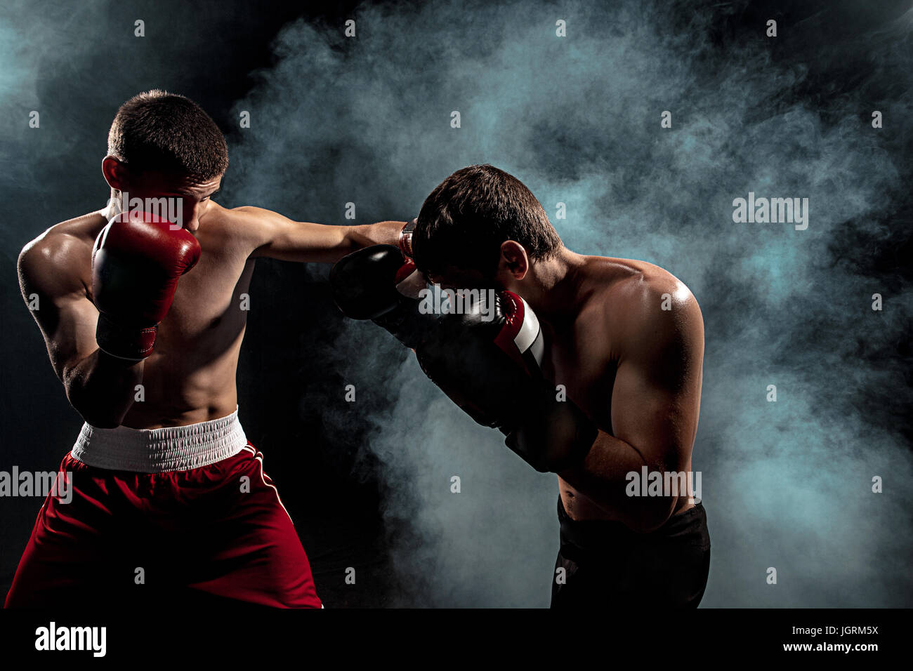 Two professional boxer boxing on black smoky background Stock Photo - Alamy