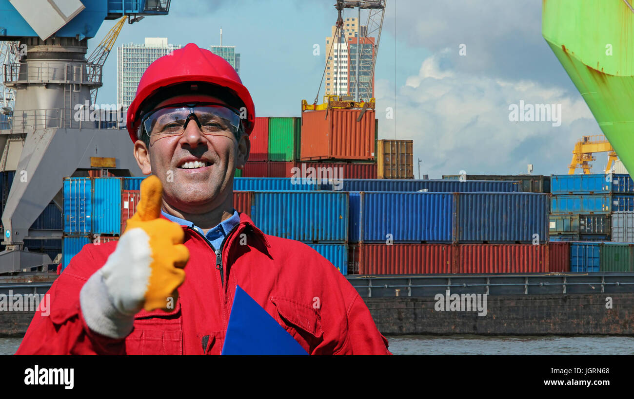Worker supervising container uploading at dock. Cargo container ship at ...