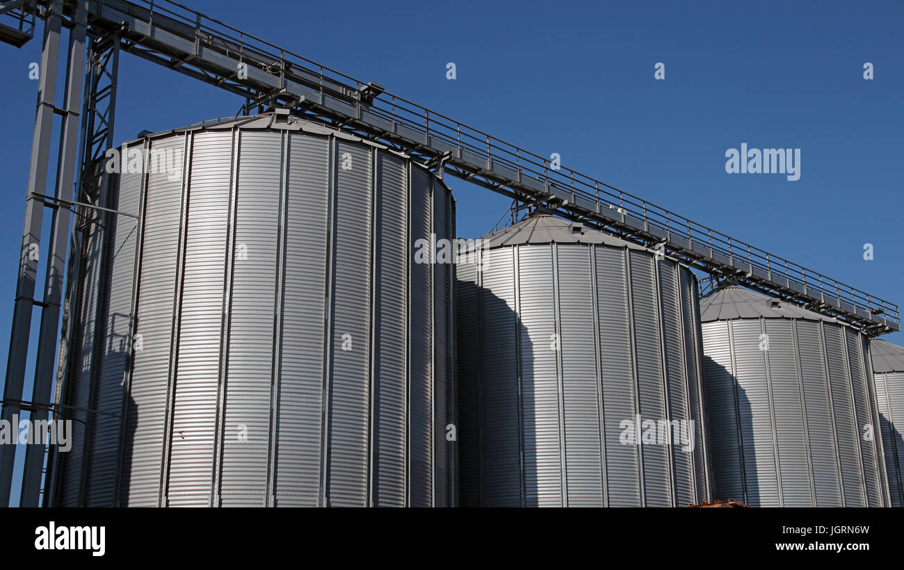 Steel grain silos used to store grain. Grain storage bins against blue ...
