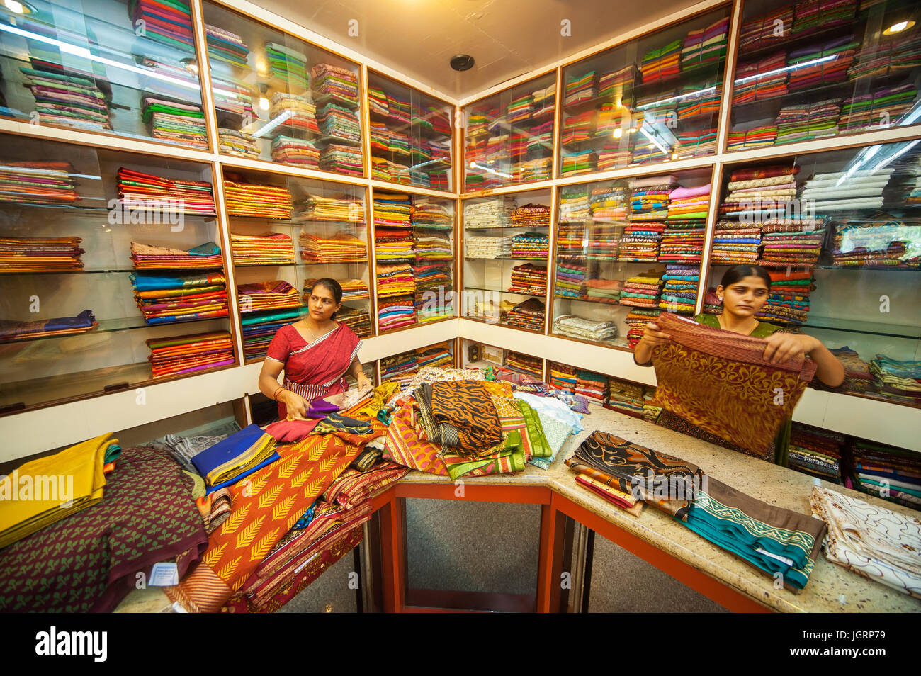 Indian womans waiting for customers at an traditional clothes store ...