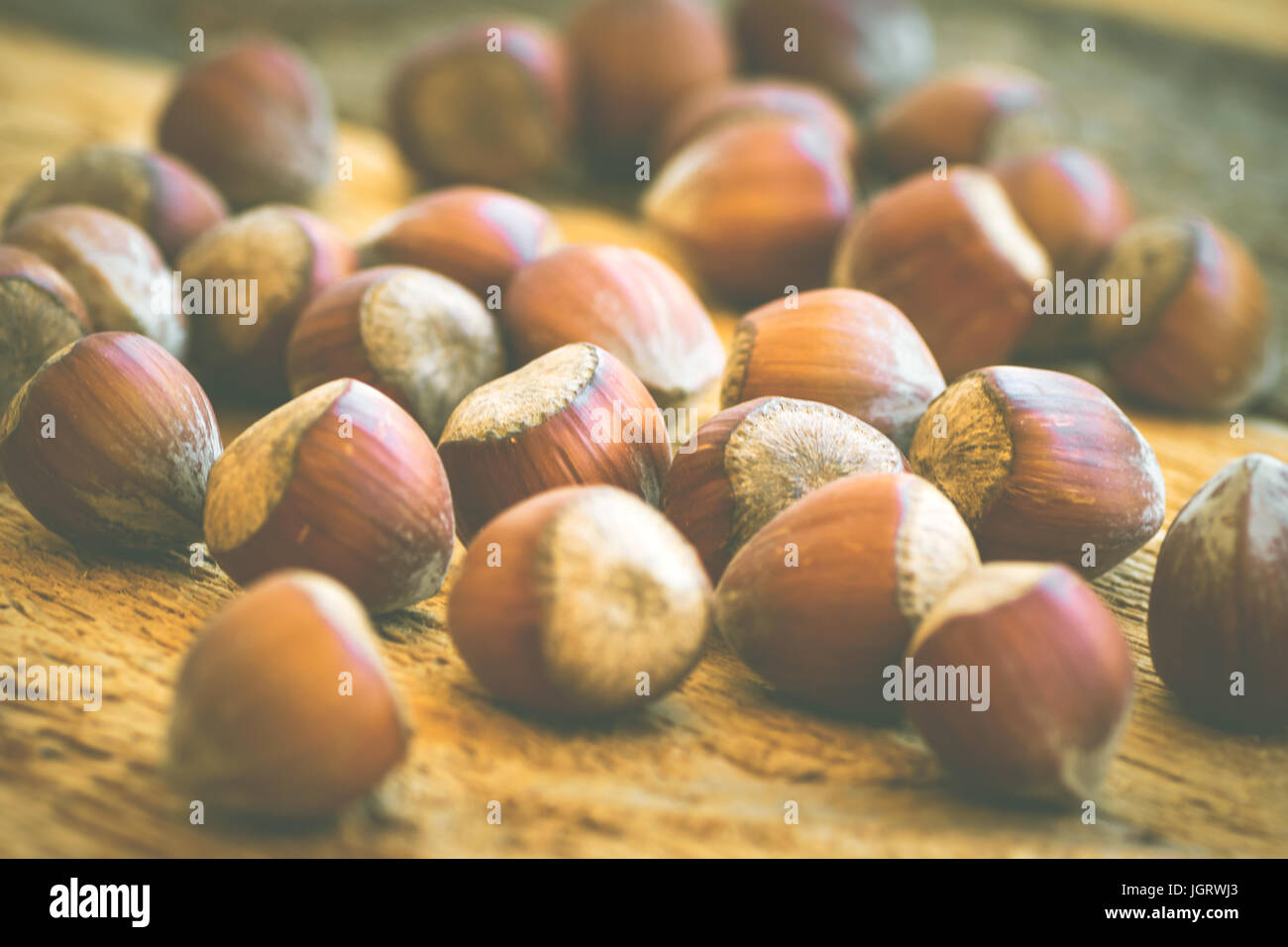 Whole hazelnuts in shells scattered on weathered wood background, soft ...