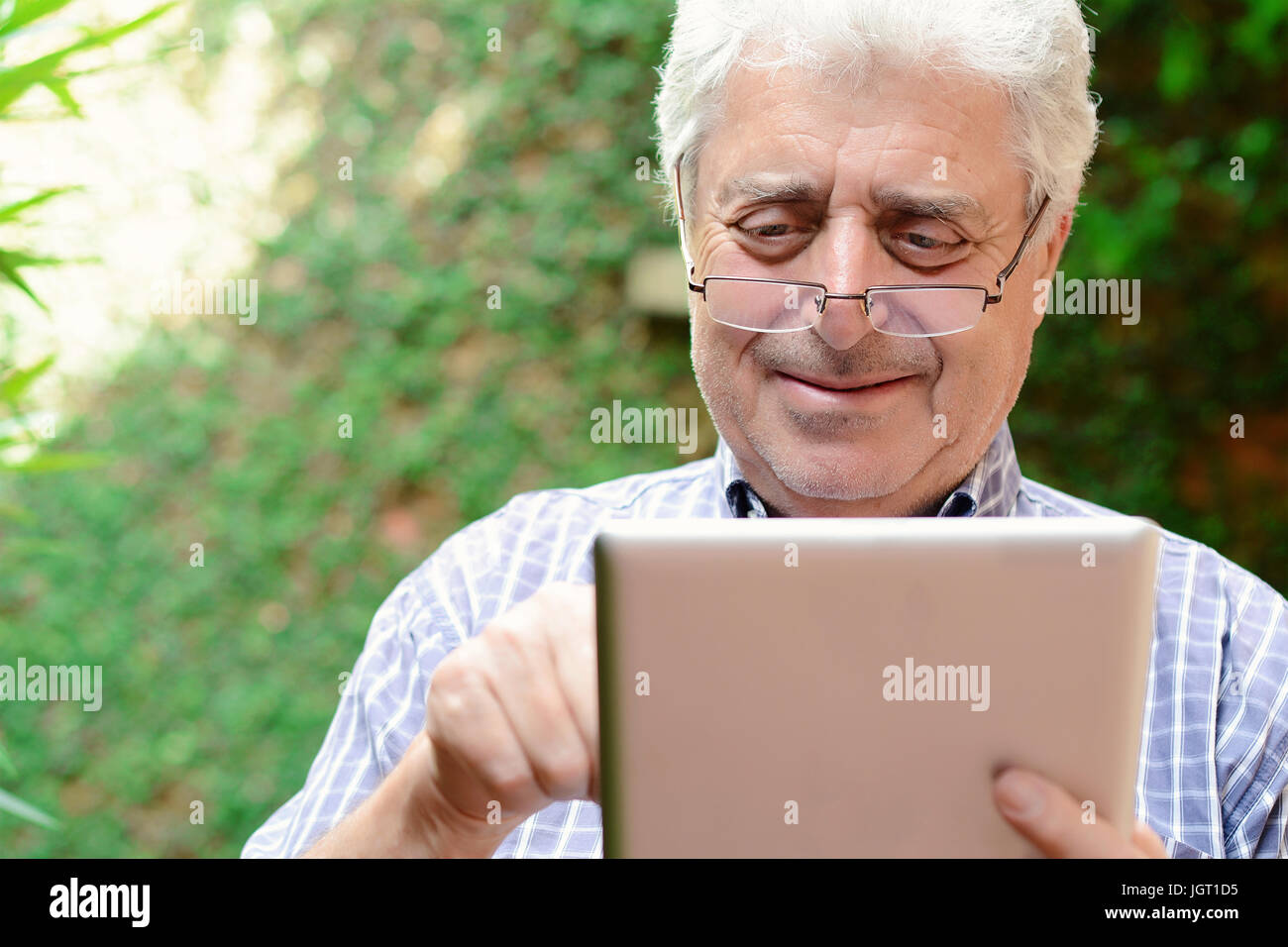Portrait of an old man using digital tablet. Outdoors Stock Photo - Alamy