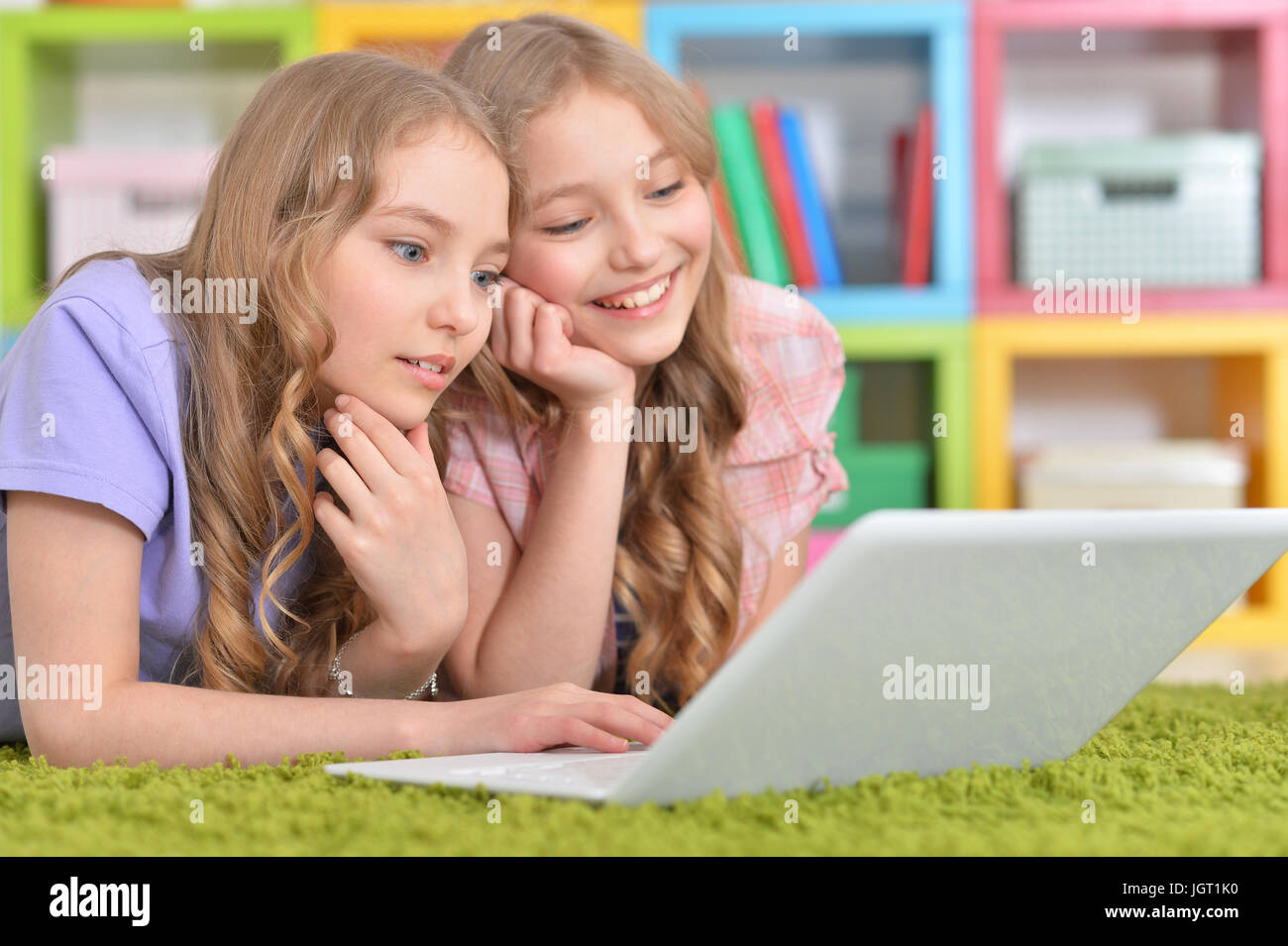 Teenagers sisters using laptop Stock Photo - Alamy