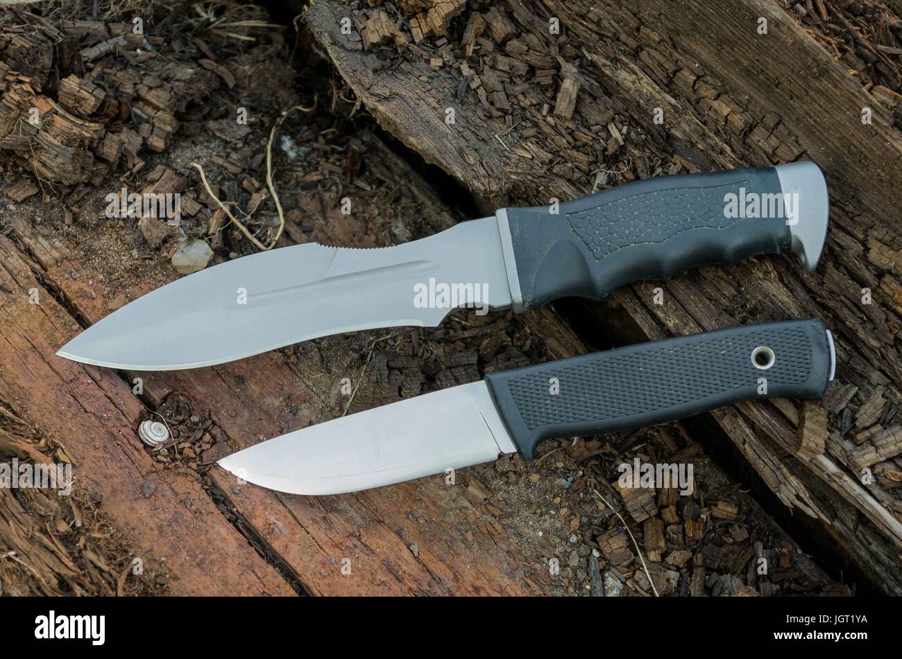 Knives on wood log. Side view. Background is brown Stock Photo - Alamy