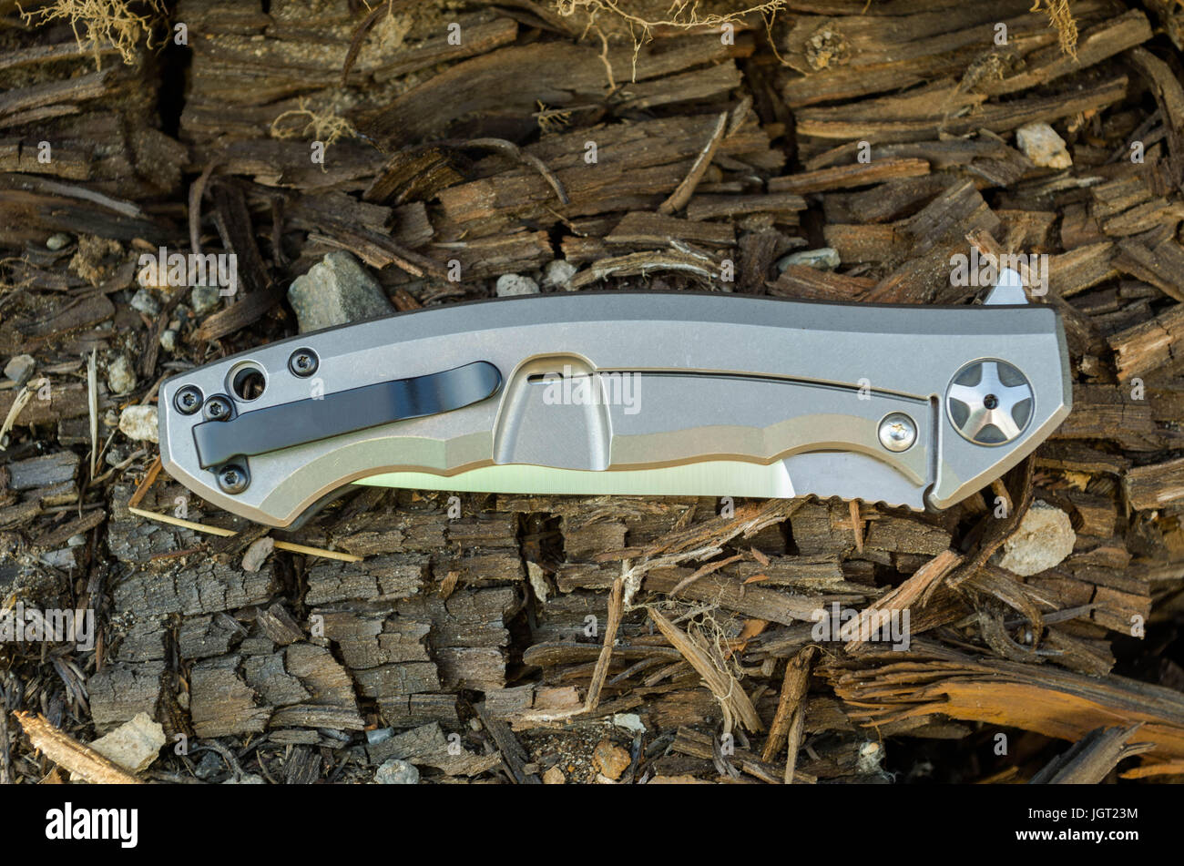 Knife with a titanium hilt in folded form. Wood background Stock Photo ...