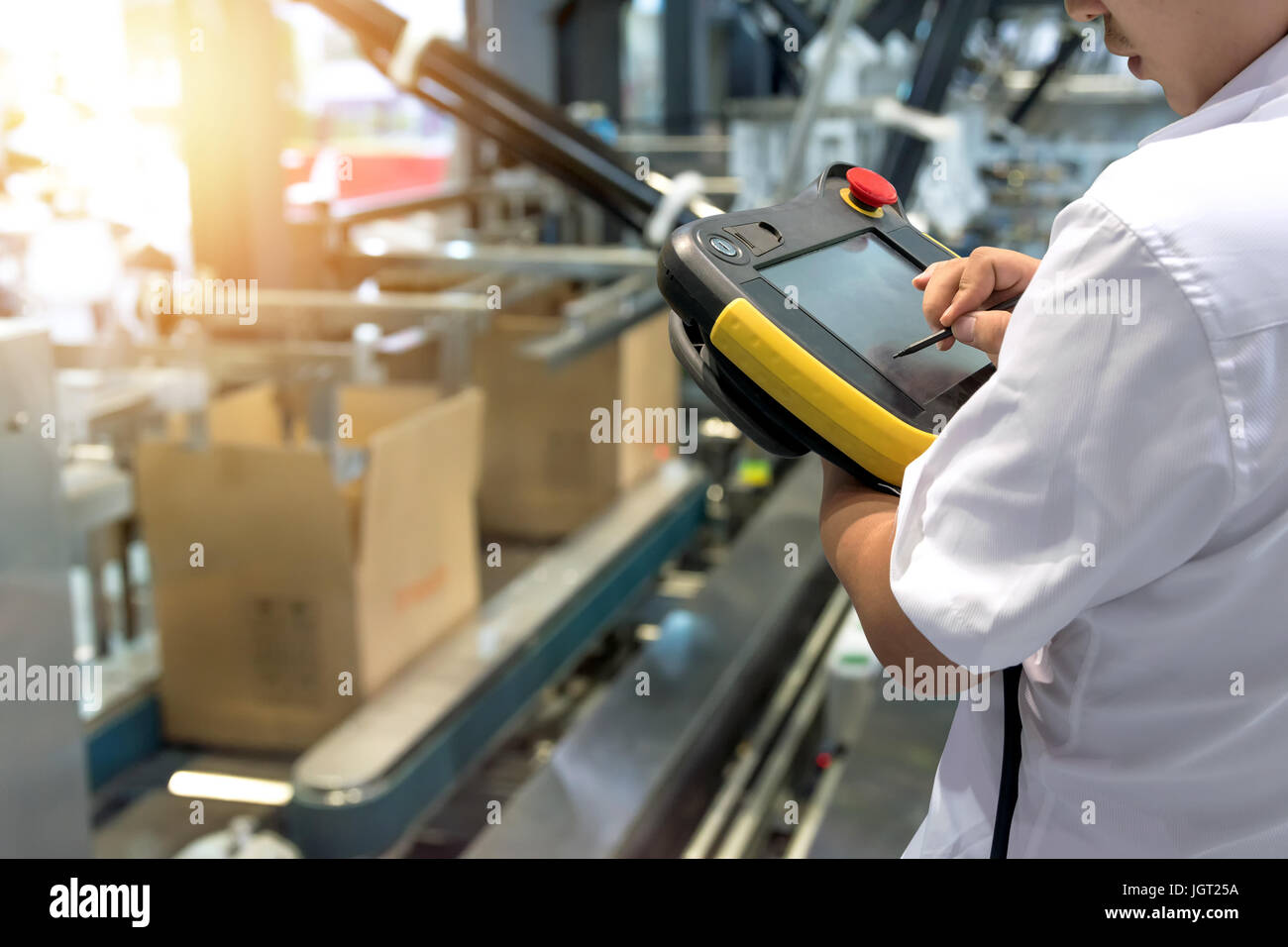 Engineer hand holding machine controller tablet to control package ...