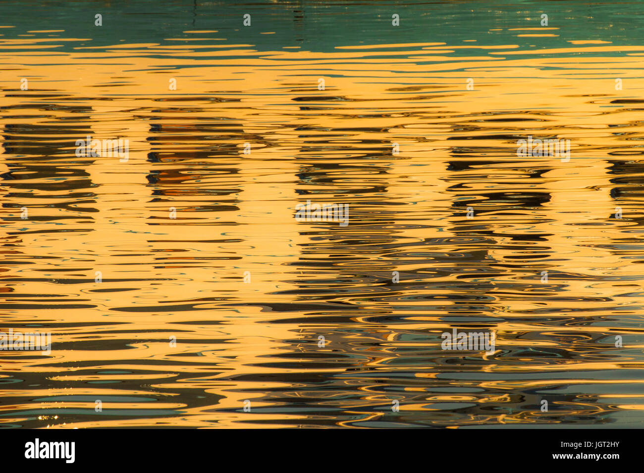 Reflection of windows in the waters of lake created by the light of the ...