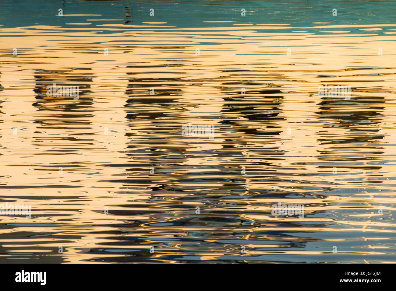 Reflection of windows in the waters of lake created by the light of the ...