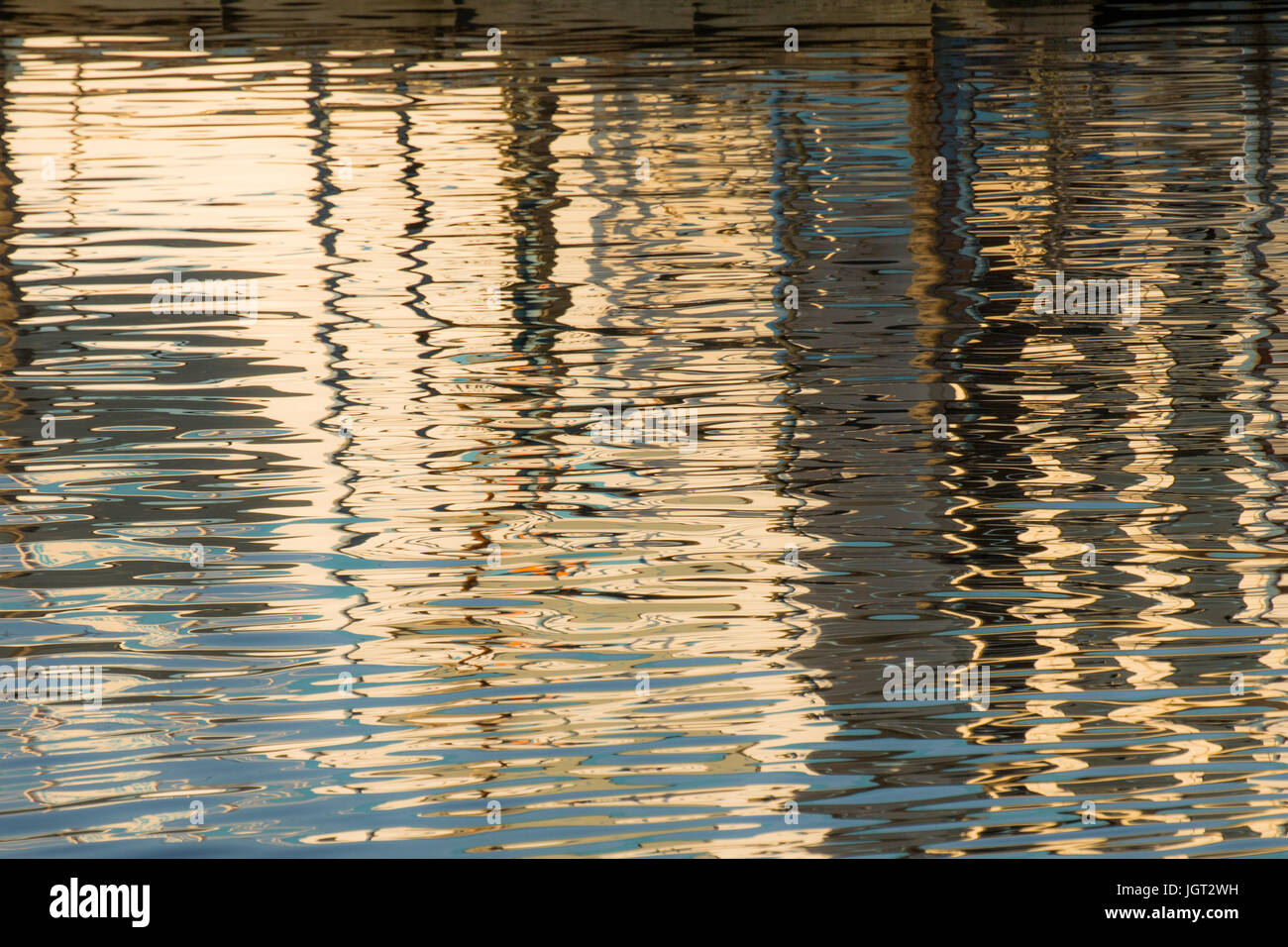 Reflection of a pier in the waters of lake created by the light of the ...