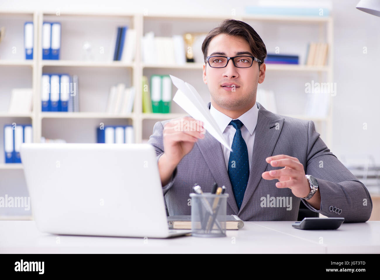 Businessman with paper airplane in office Stock Photo - Alamy