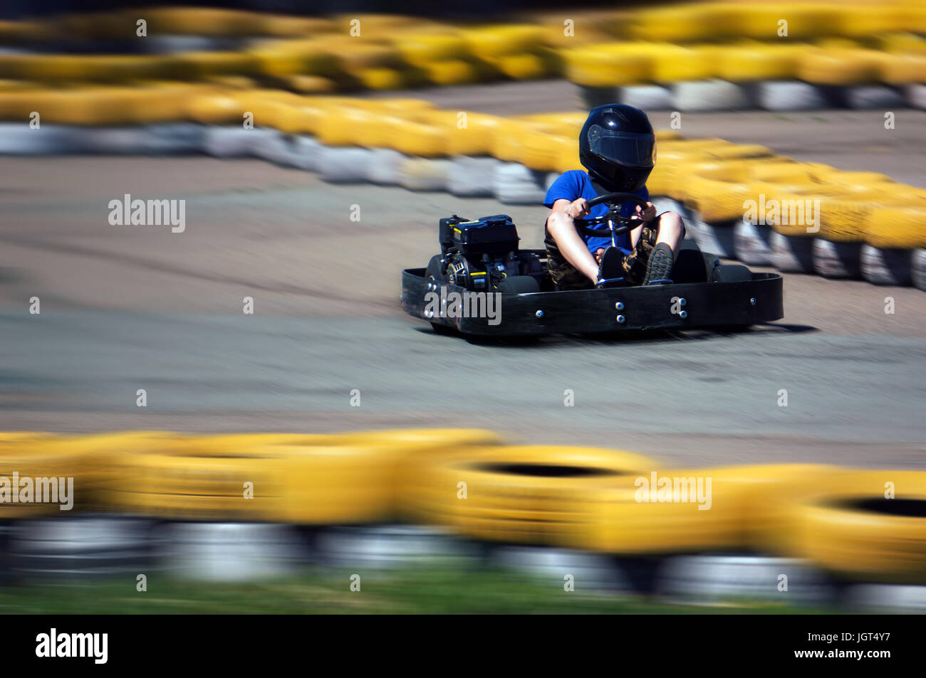 Youth Go Kart Racer on track. Shot is panned to emphasize speed Stock ...