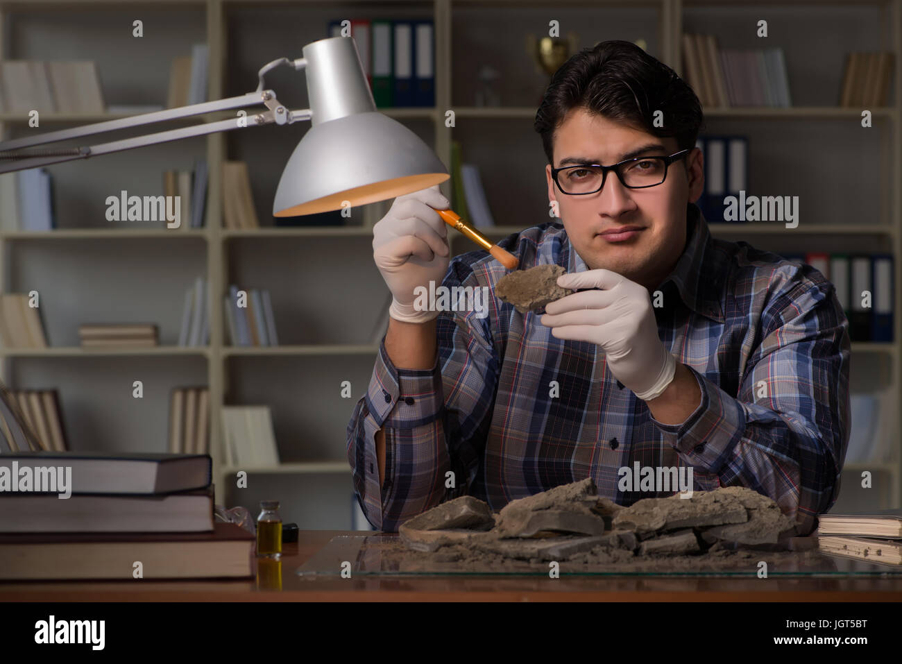 Archeologist working late night in office Stock Photo - Alamy