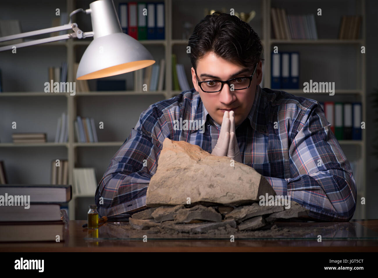 Archeologist working late night in office Stock Photo - Alamy