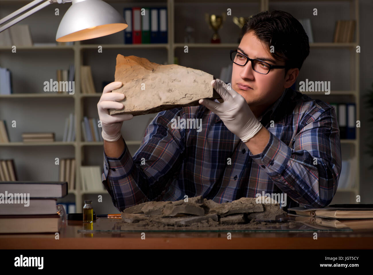 Archeologist working late night in office Stock Photo - Alamy