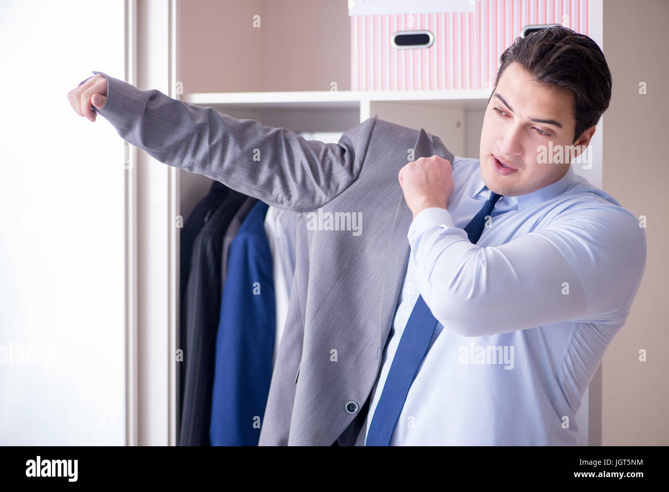 Young man businessman getting dressed for work Stock Photo - Alamy