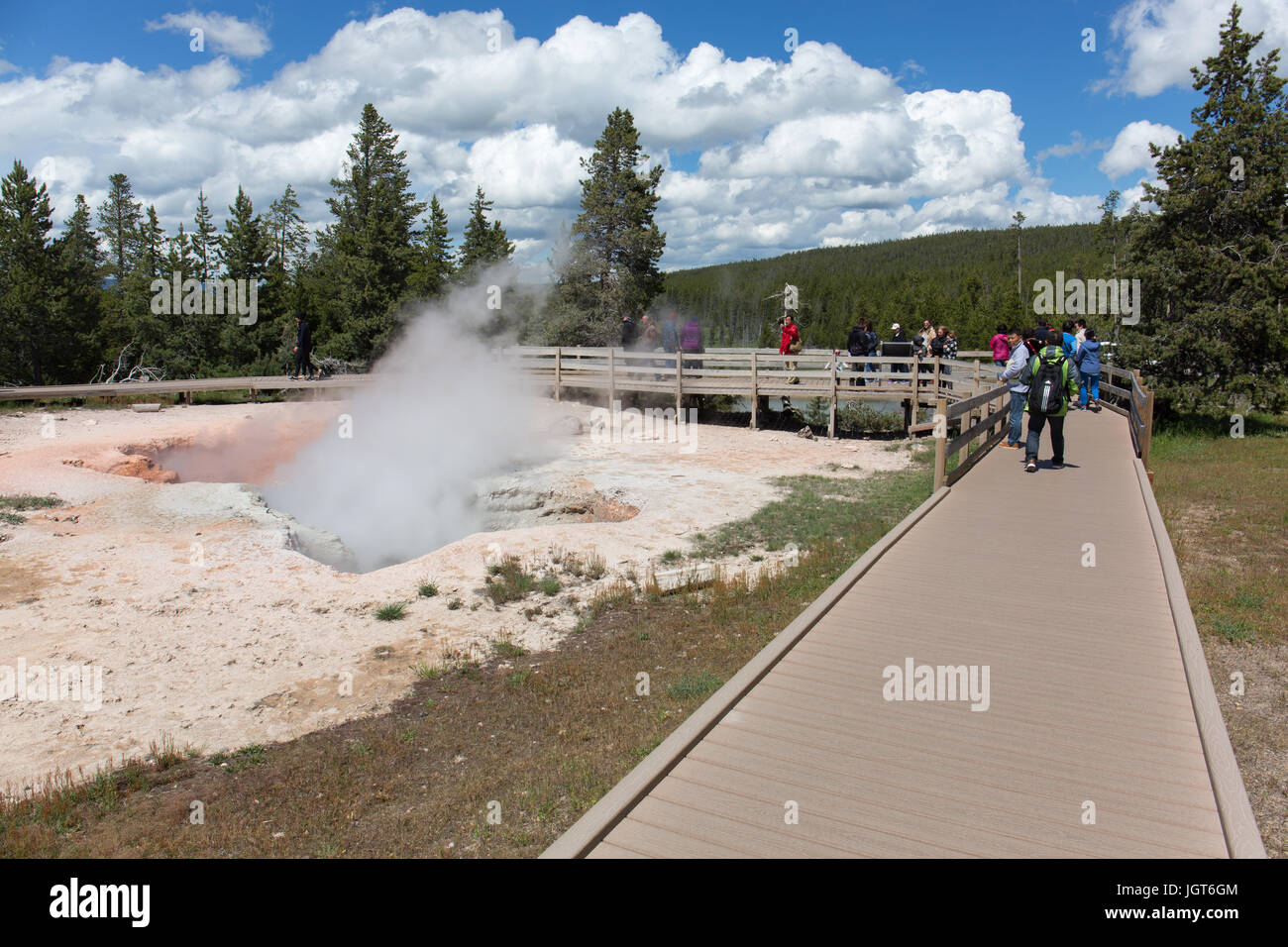 People are walking on the boardwalk of Fountain Paintpot Trail next to ...