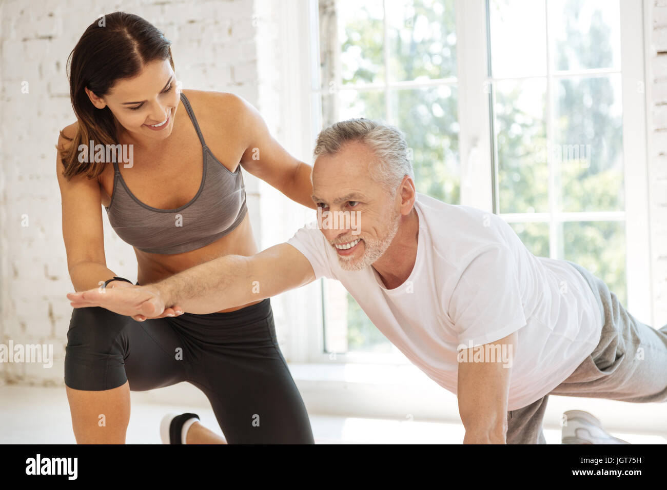 Smiling instructor supporting her client Stock Photo - Alamy