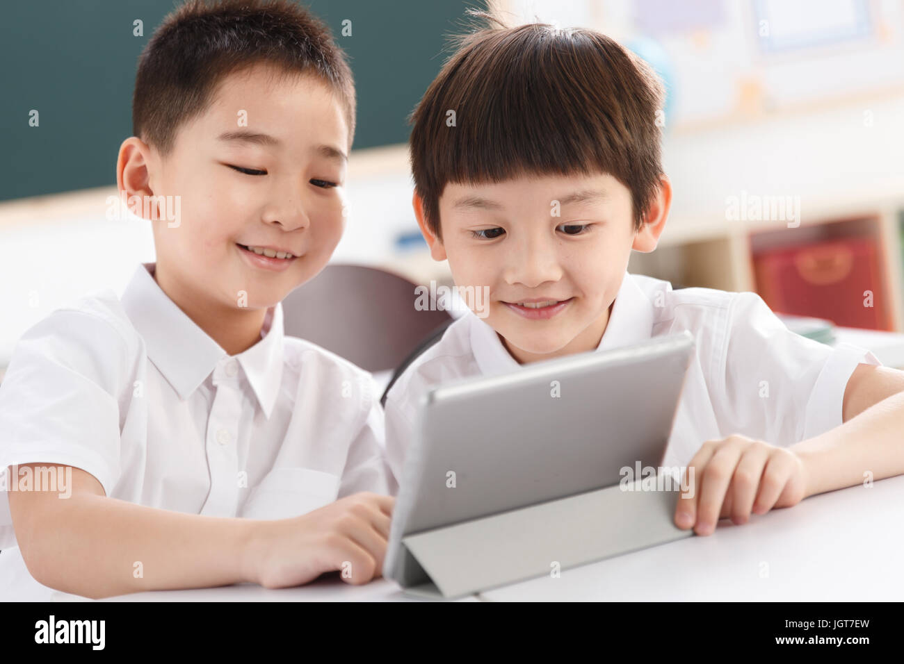Two students using digital tablet in classroom Stock Photo - Alamy