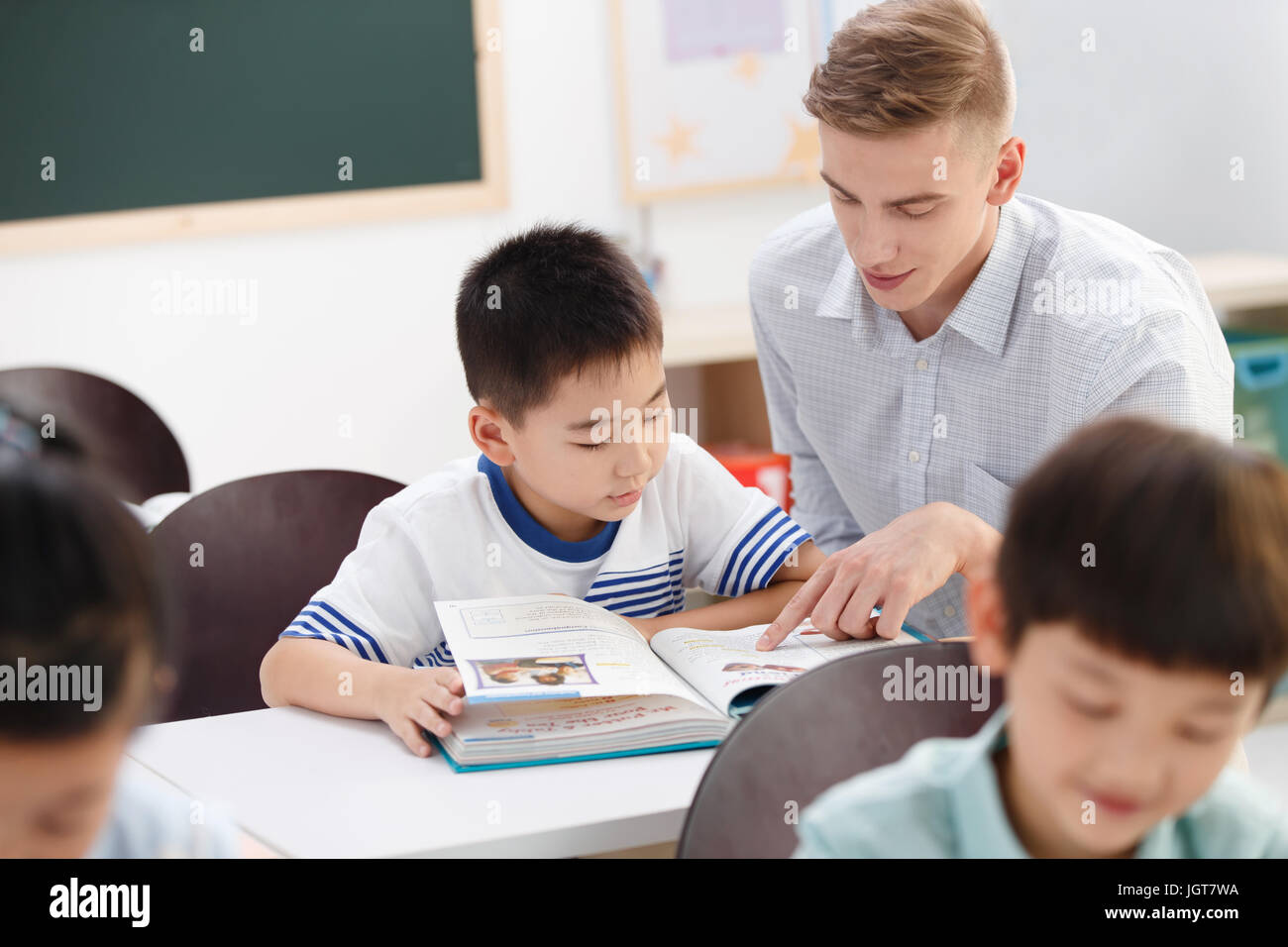 Male teacher teaching students in classroom Stock Photo - Alamy