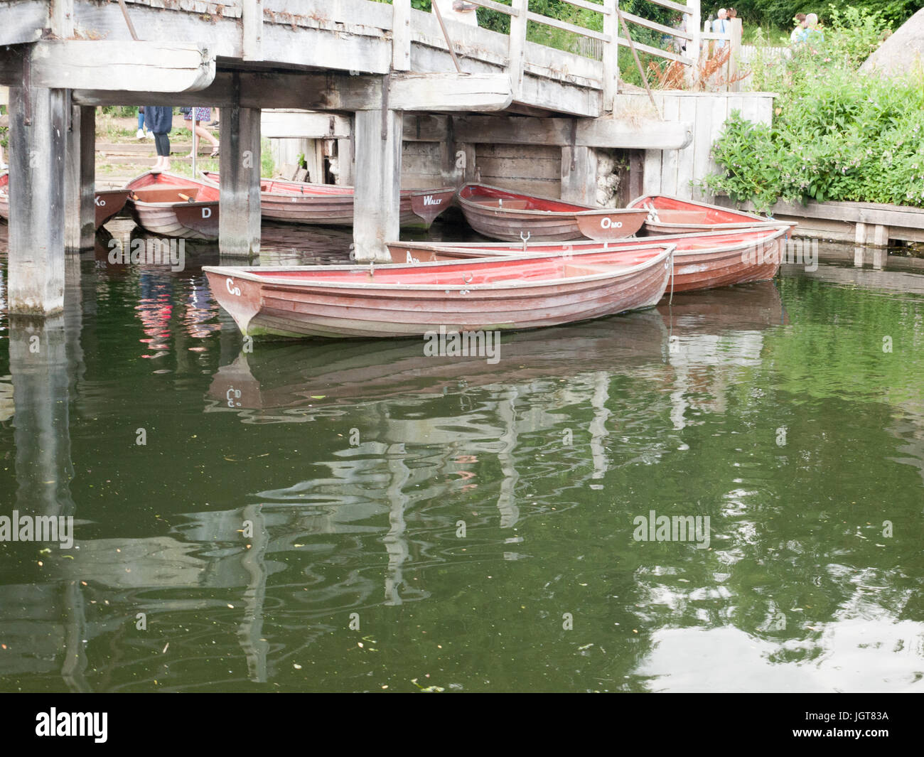 several wooden row boats moored under a bridge; Suffolk; UK Stock Photo ...