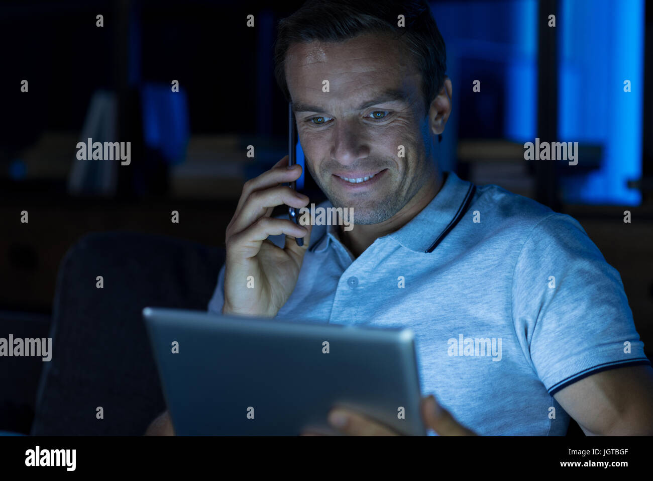 Easy going pleasant guy calling someone Stock Photo - Alamy