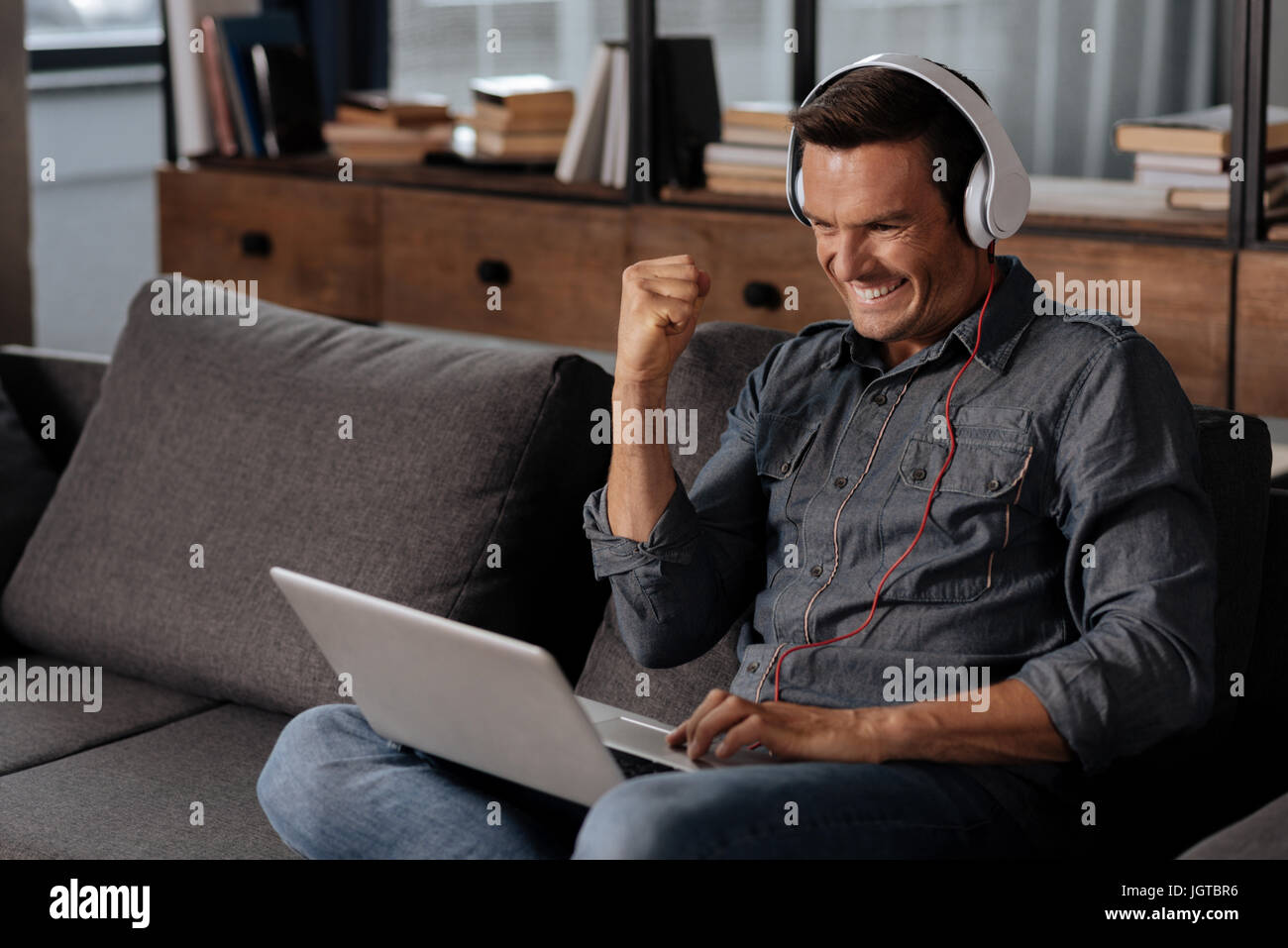 Charming emotional man winning the game Stock Photo - Alamy