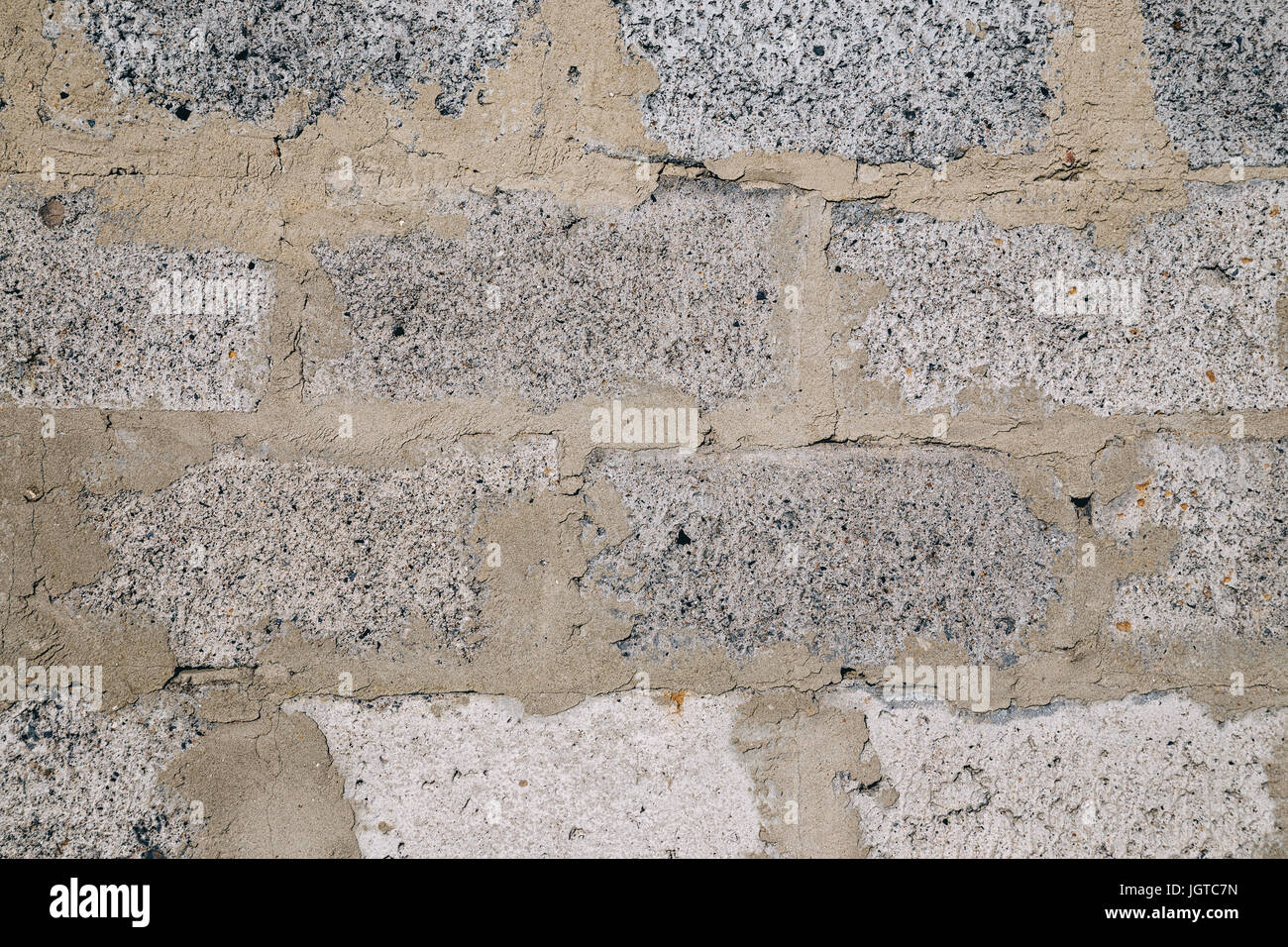 Part of an unplastered brick wall made up of gray blocks. The texture ...