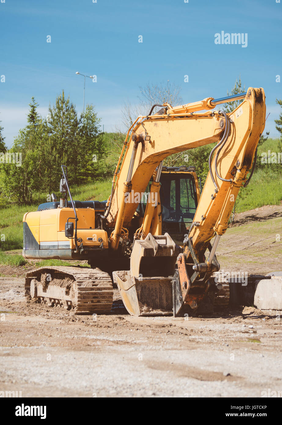 Yellow excavator on construction site Stock Photo - Alamy