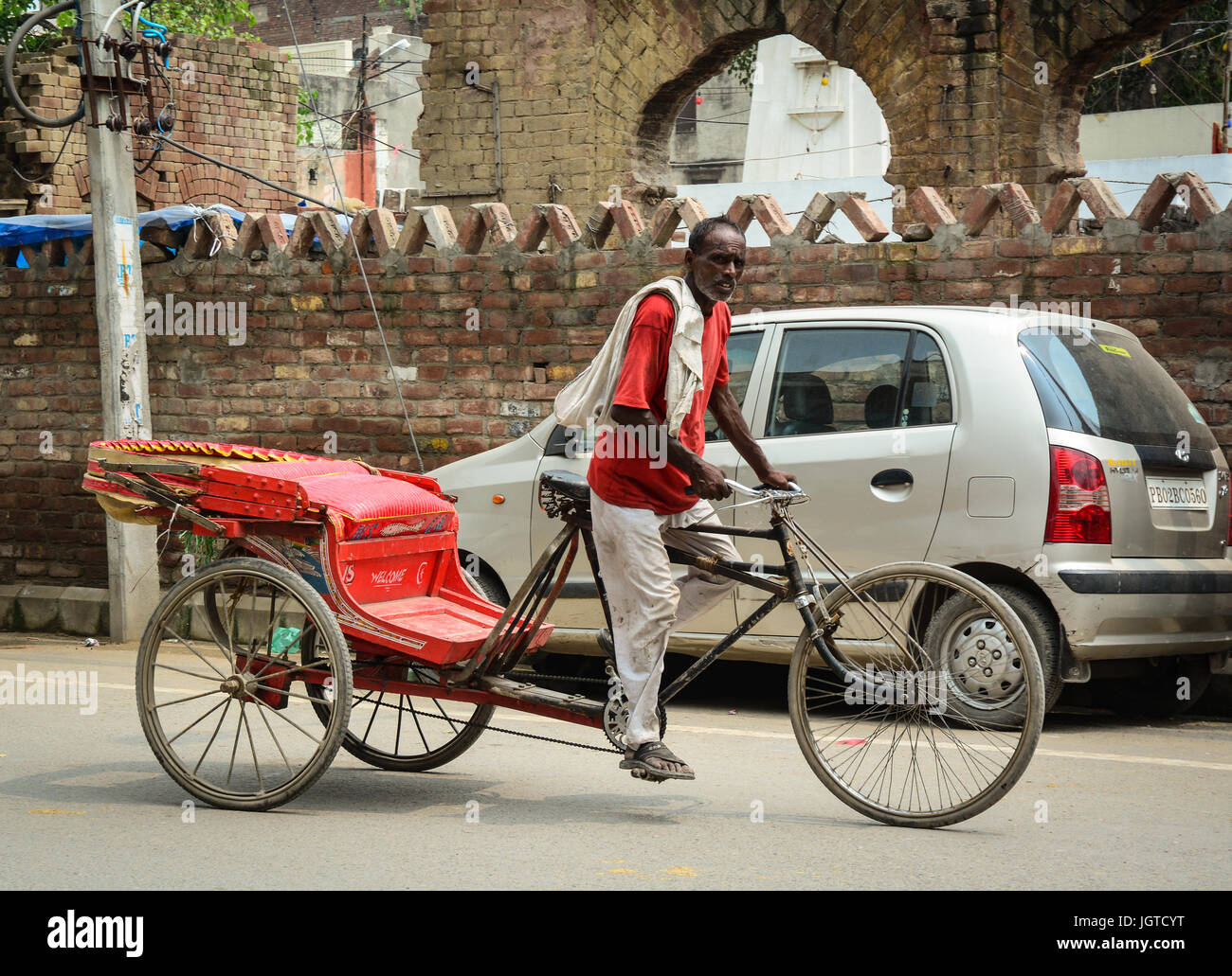 Amritsar, India - Jul 25, 2015. A man riding rickshaw on street in ...
