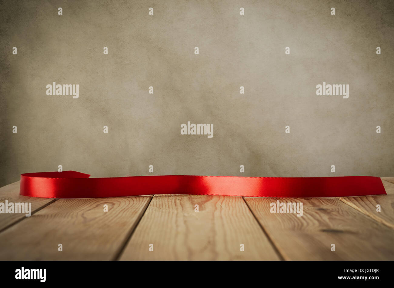 A red satin ribbon, curved and facing front to provide copy space for ...