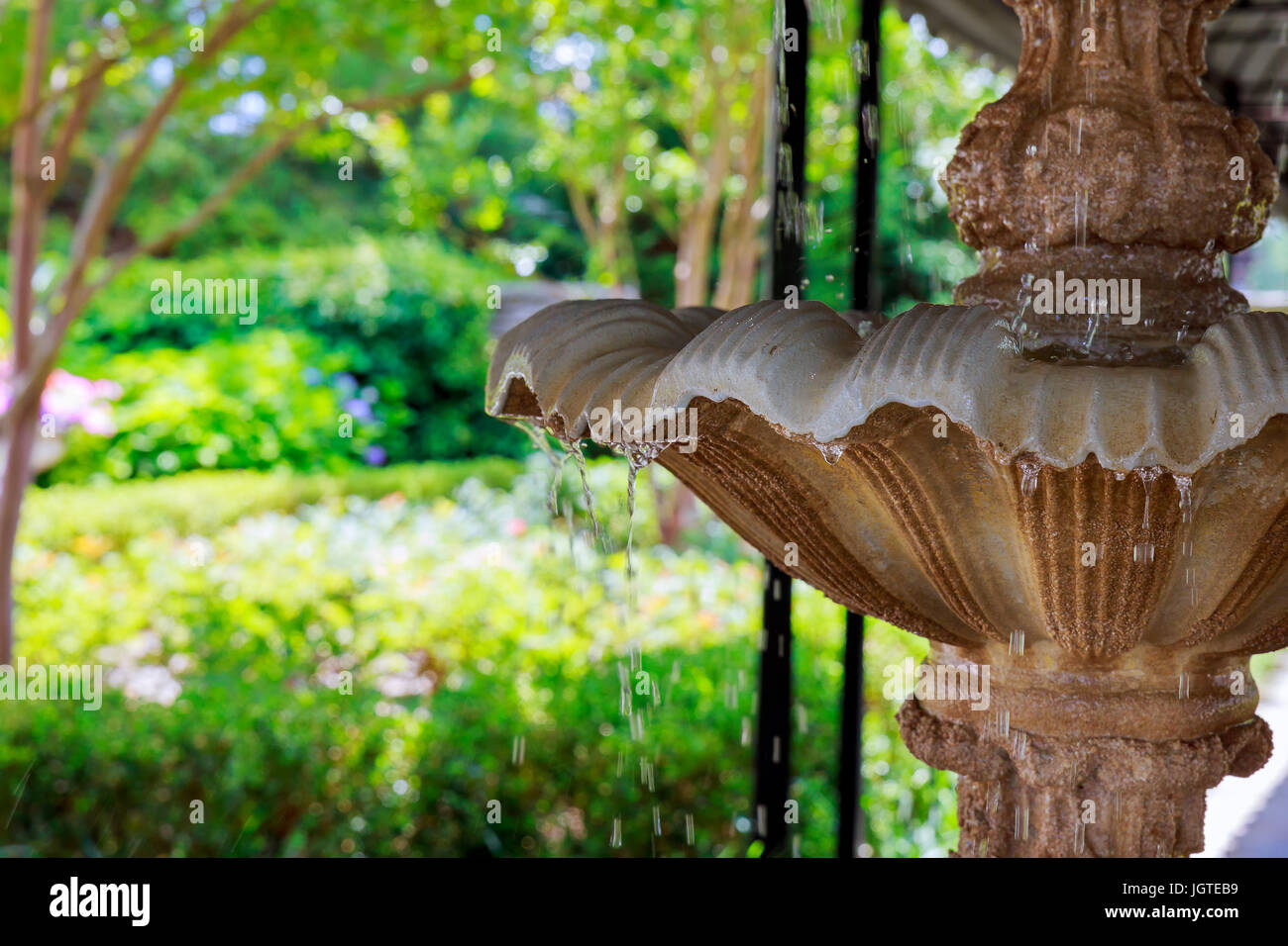 Garden with small fountain and benches around Fountain of water drops ...