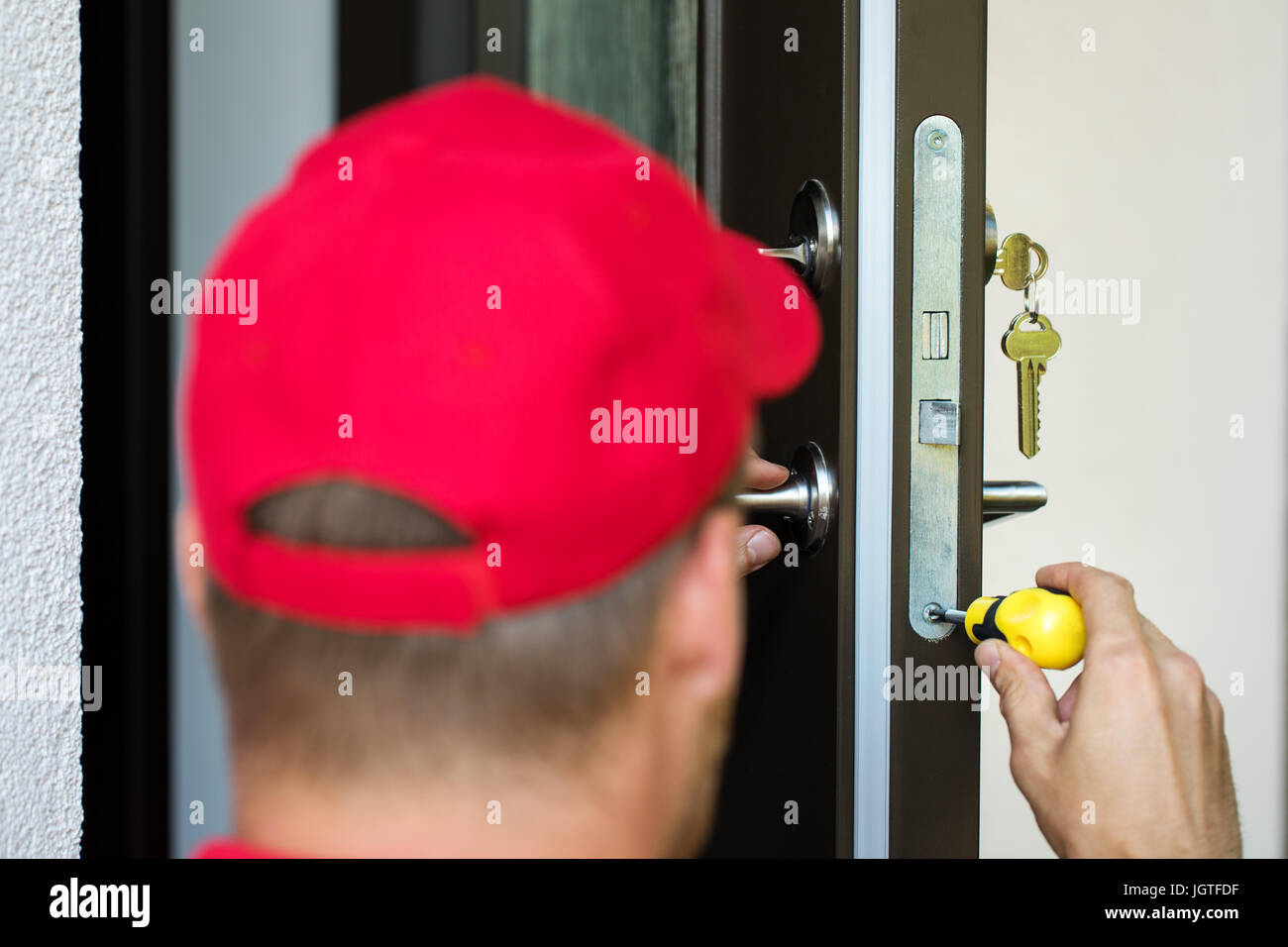 door lock service - locksmith working with screwdriver Stock Photo - Alamy