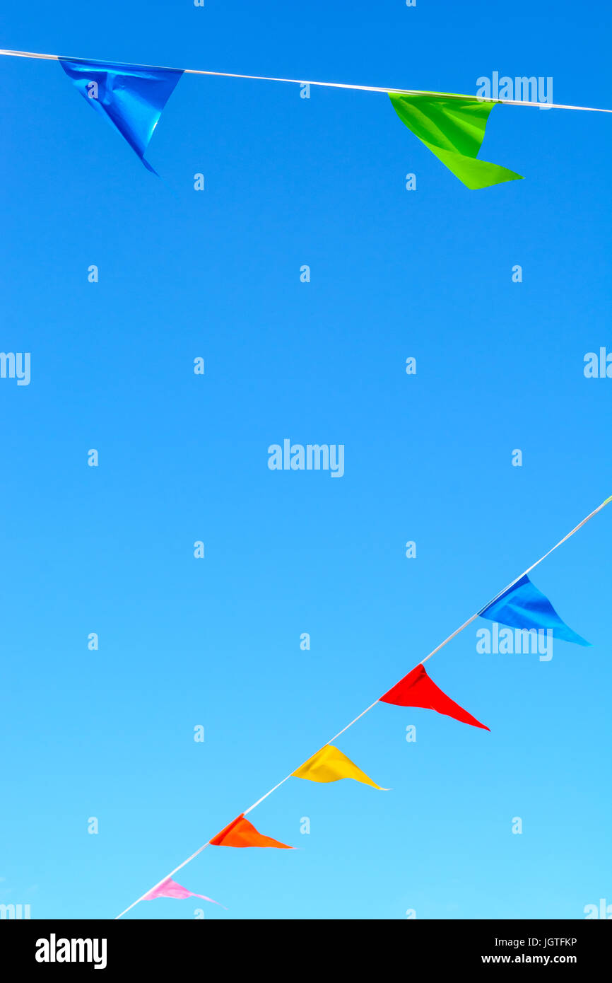 Bunting with colorful triangular party flags blowing in the wind ...