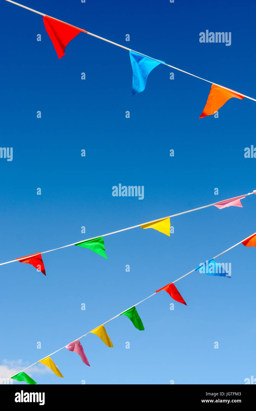 Bunting with colorful triangular party flags blowing in the wind ...