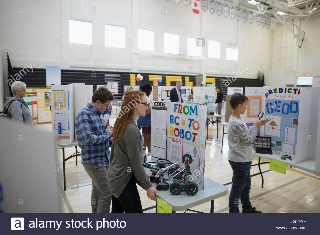 Middle school students looking at science projects at science fair ...