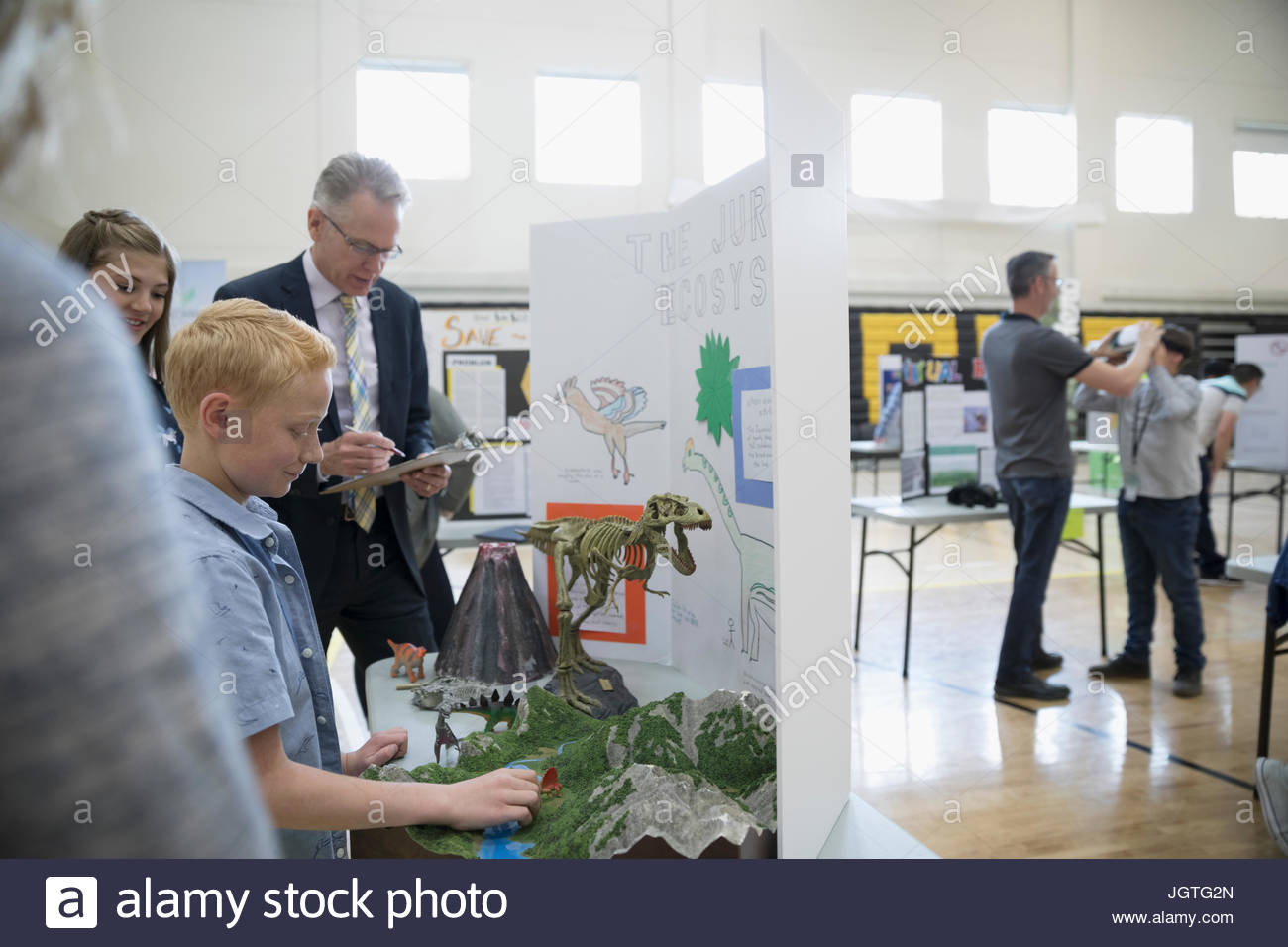 Teacher and middle school students viewing science project at science ...